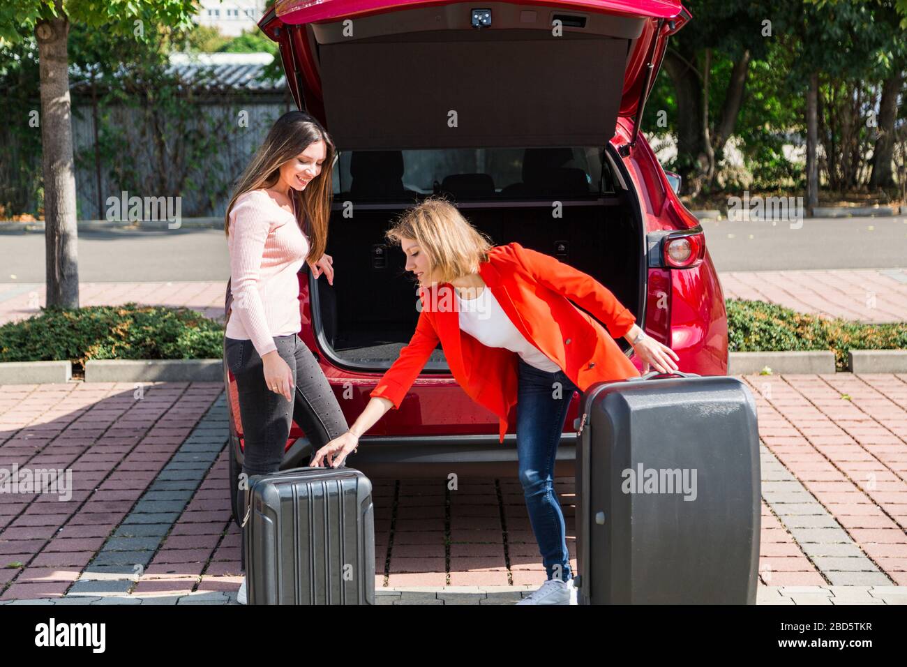 Preparing of two young girls friends for road trip Stock Photo - Alamy