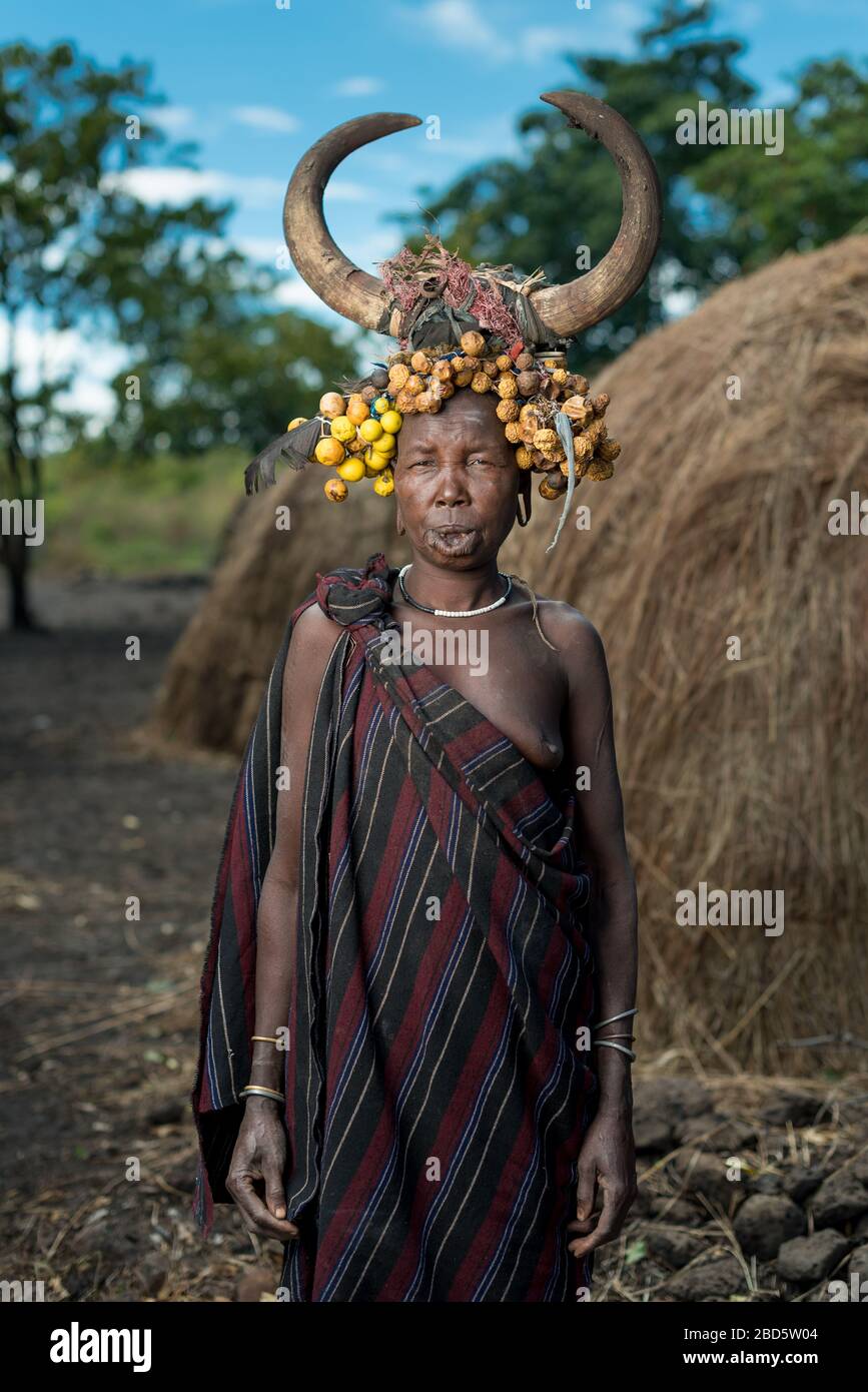 With her clay lip plate removed woman with dried fruit and cattle horn ...