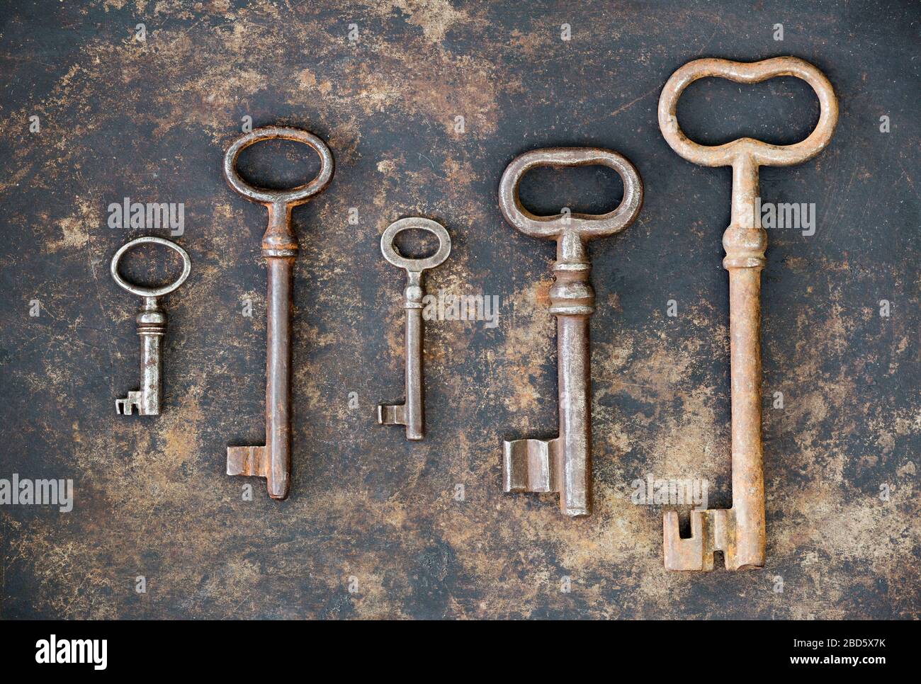 Escape room concept, group of antique keys on rusty metal background ...