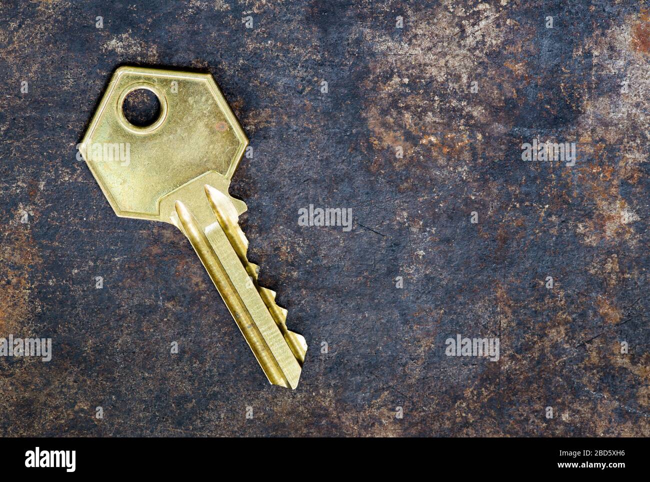 Golden house door key on a rusty metal background Stock Photo - Alamy