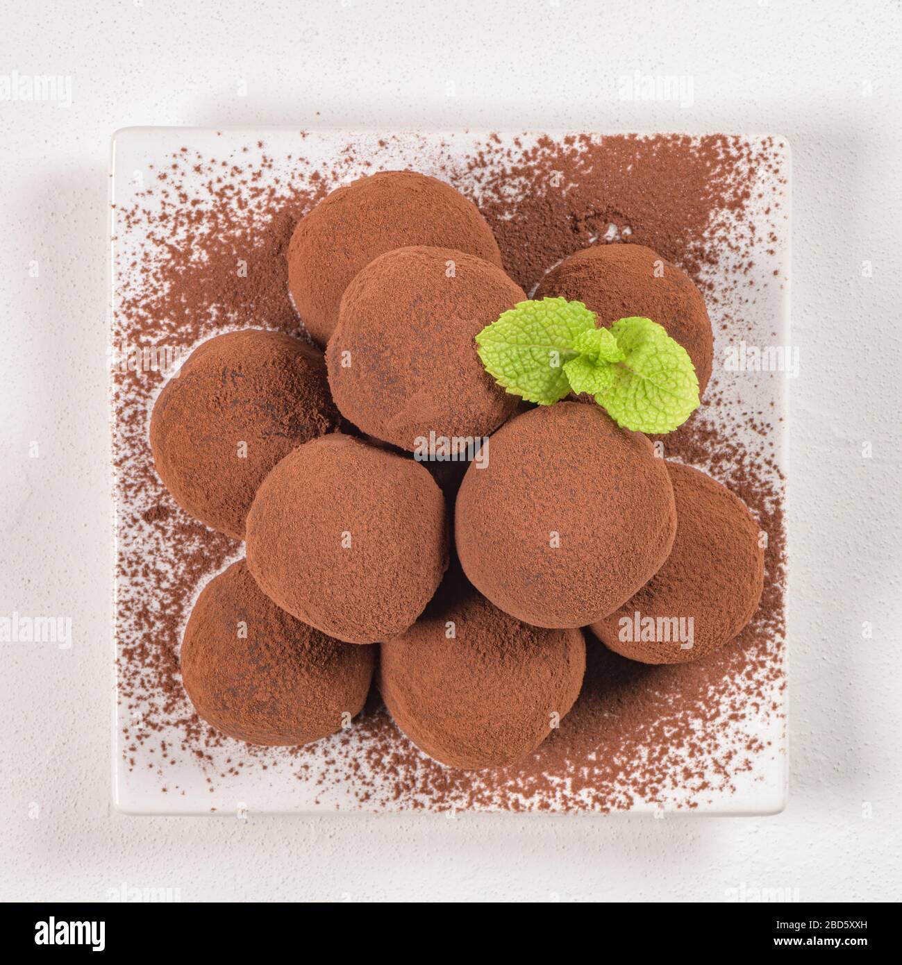 Fine chocolate truffles on white ceramic plate Stock Photo - Alamy