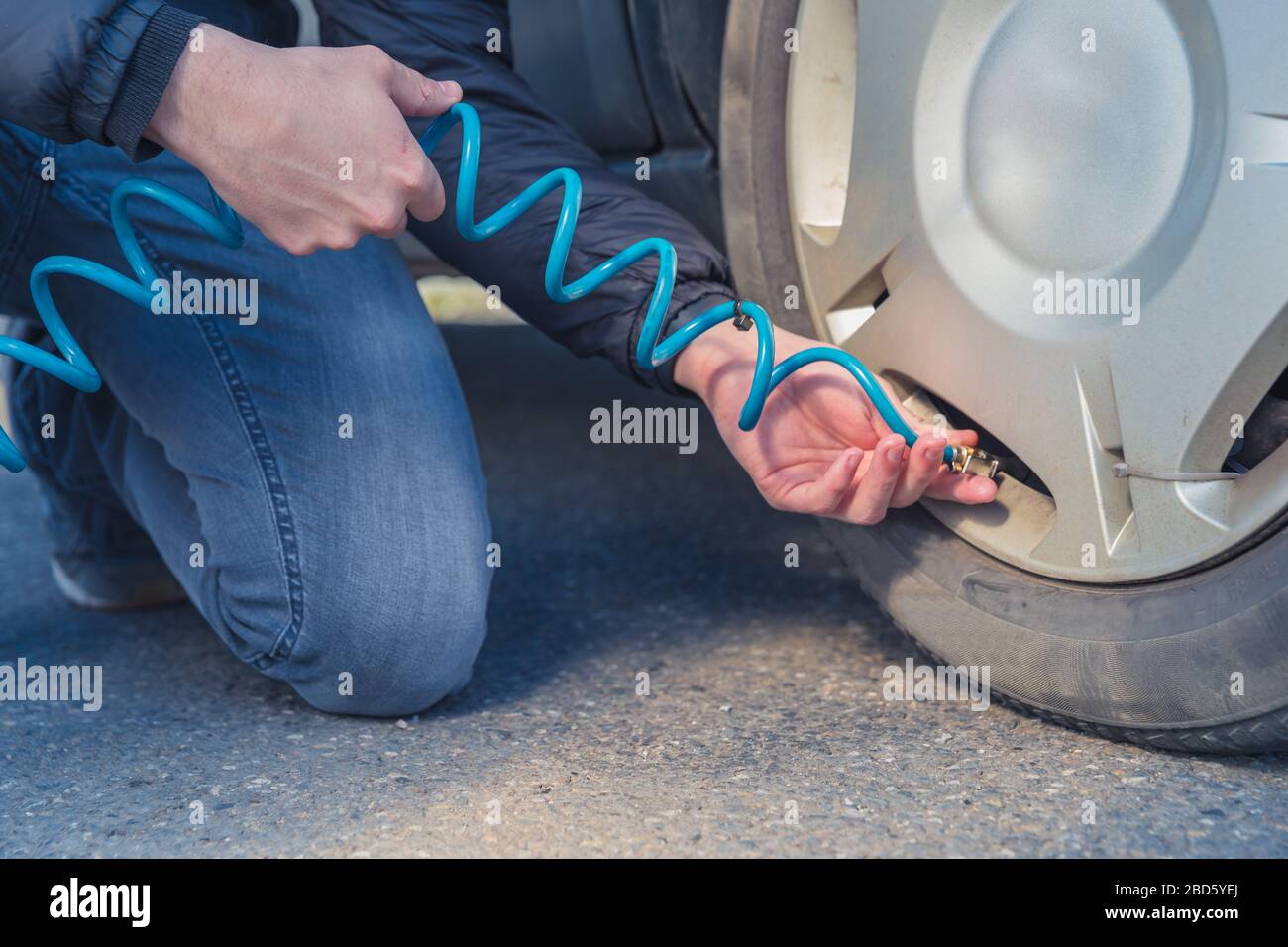 inflating the car tires with air using a compressor Stock Photo - Alamy
