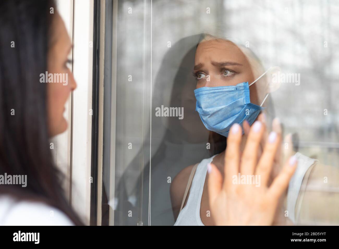 Unhappy Girl Touching Mother's Hand Through Glass Door At Home Stock ...