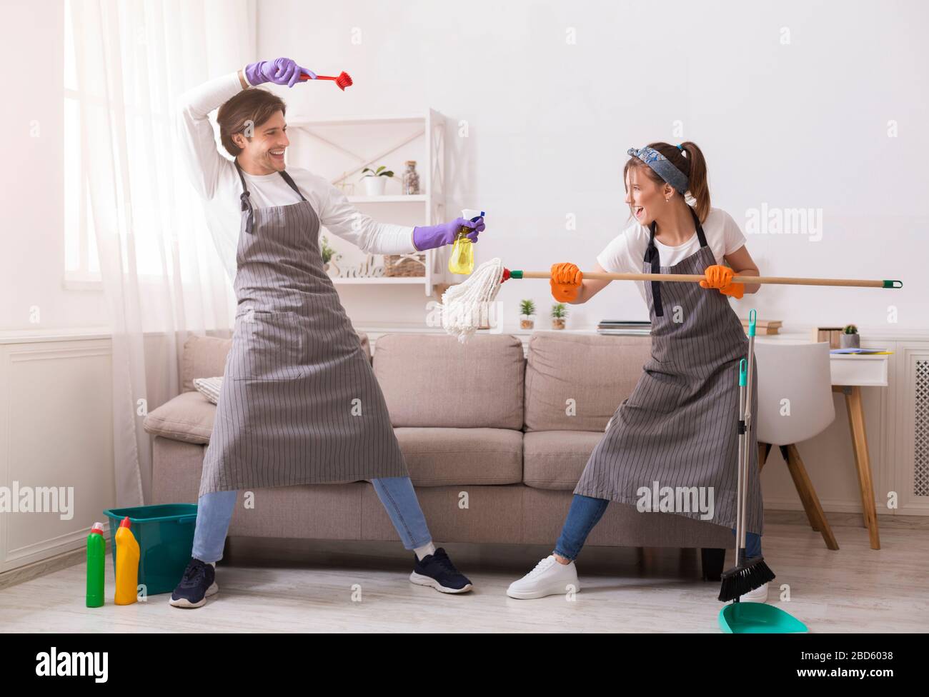 Happy Couple Fooling While Cleaning Up Their Flat, Playfully Fighting ...