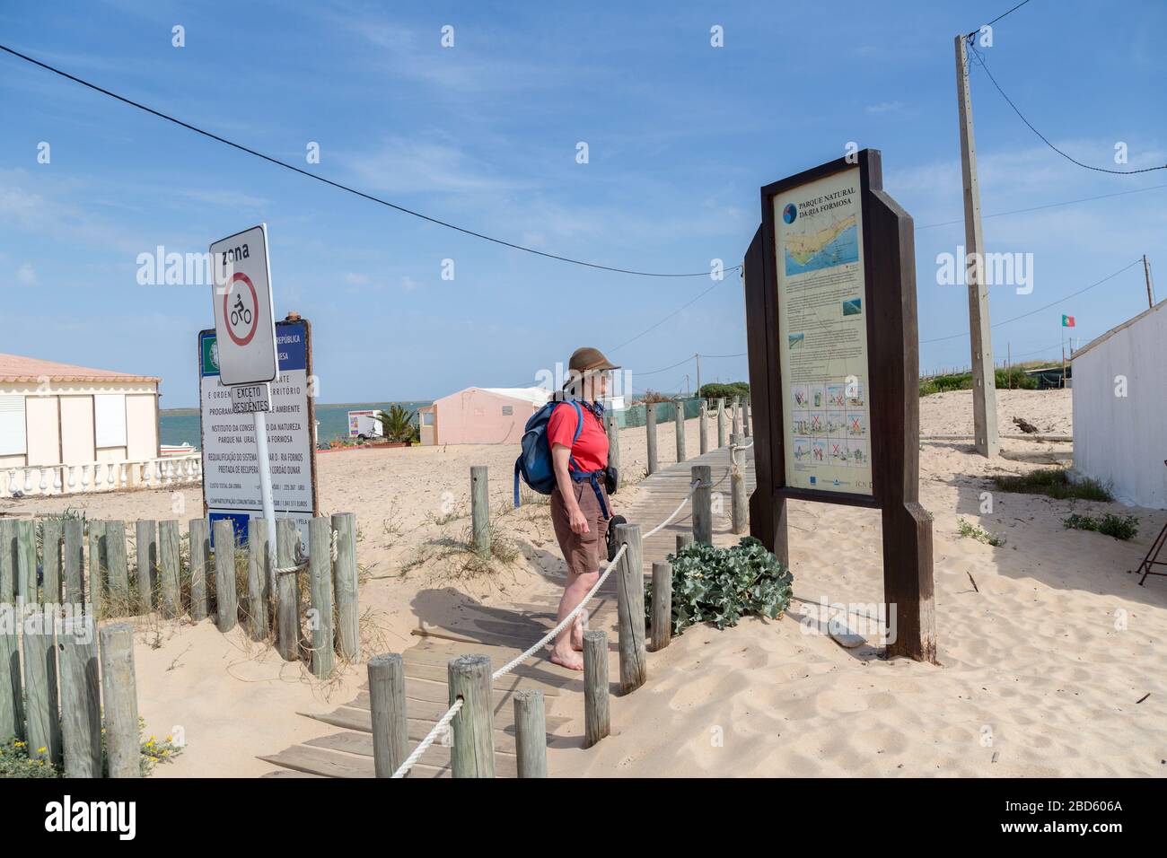 Reading information signs at the entry to the boardwalk for Praia de ...