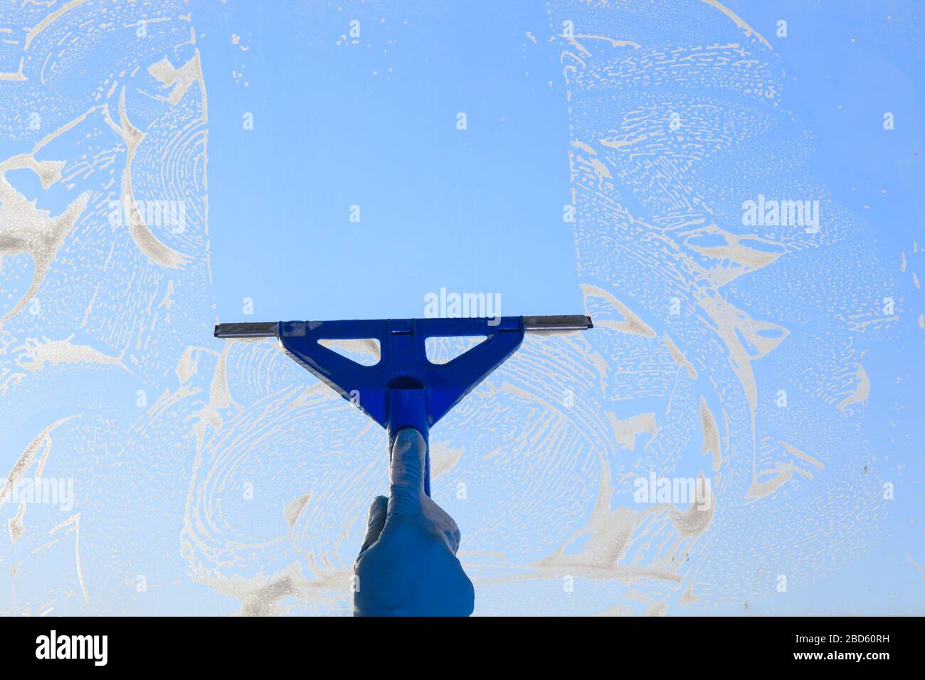 housekeeping: cleaning the windows, Window cleaner using a squeegee ...