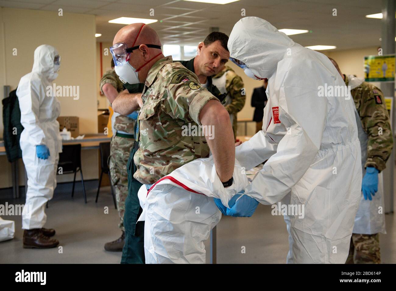 Members of the British Army learn how to apply PPE during training to ...