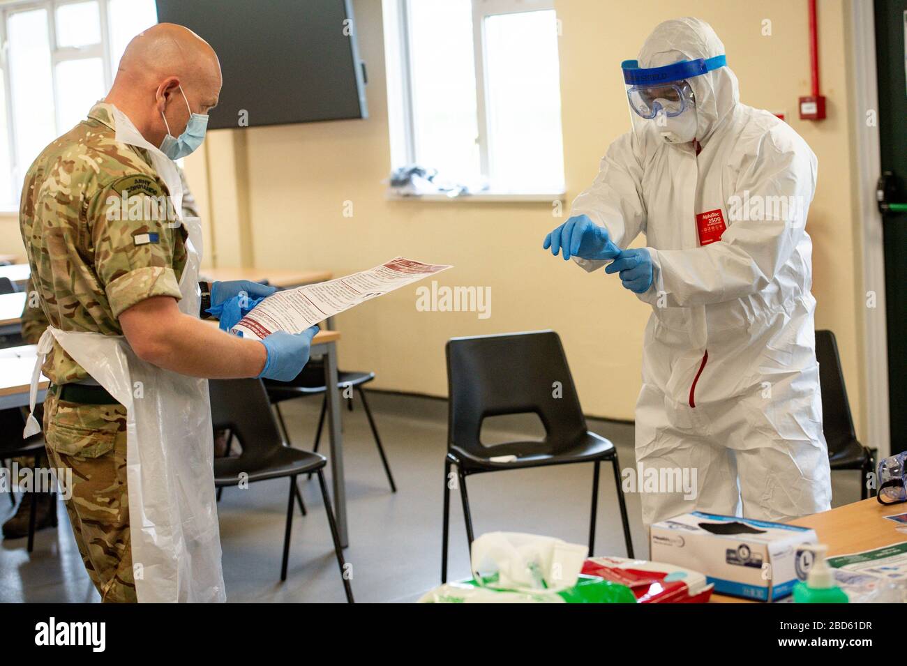 Members of the British Army learn how to apply PPE during training to ...