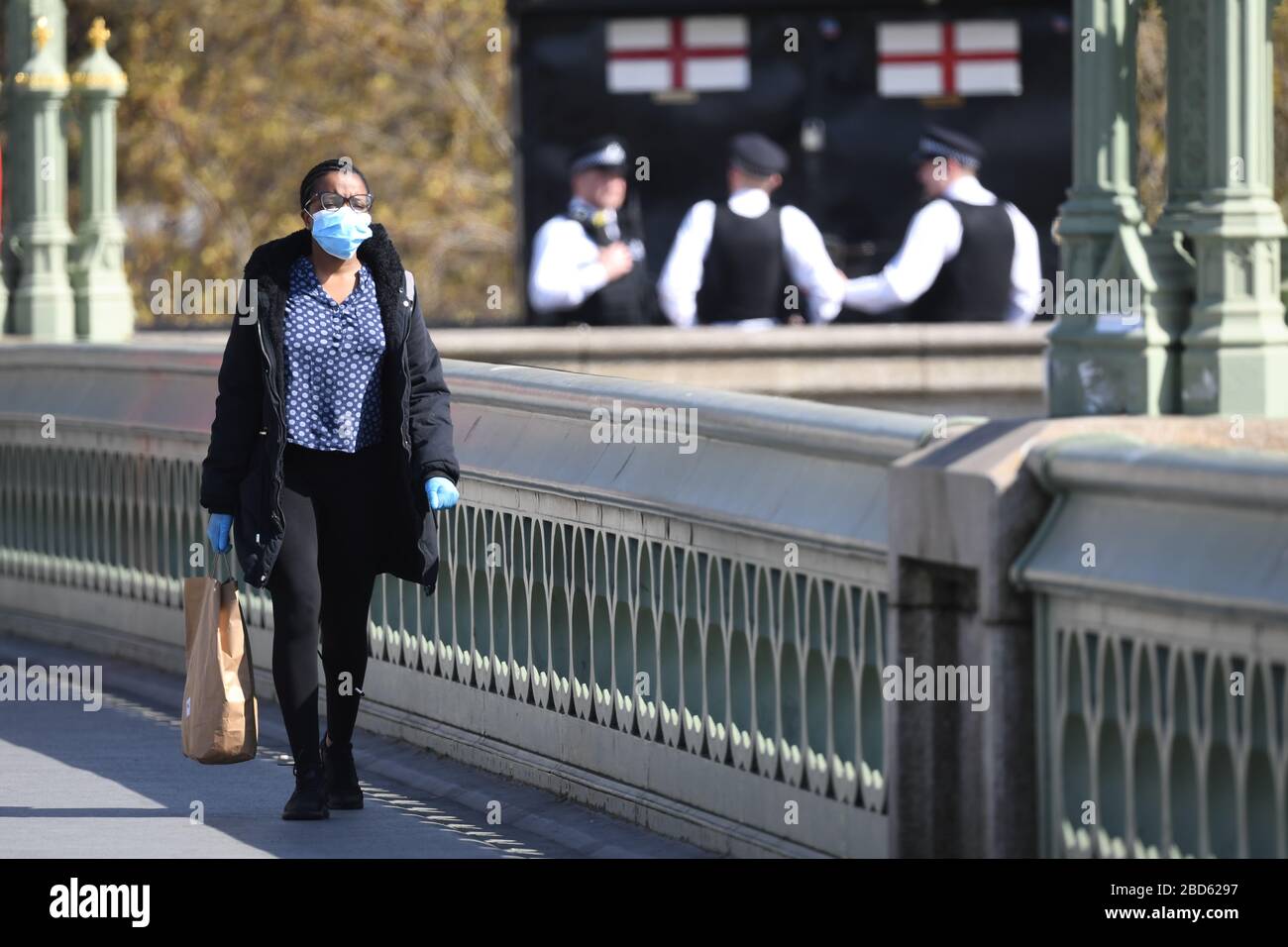 A woman walks across Westminster Bridge in London as the UK continues ...