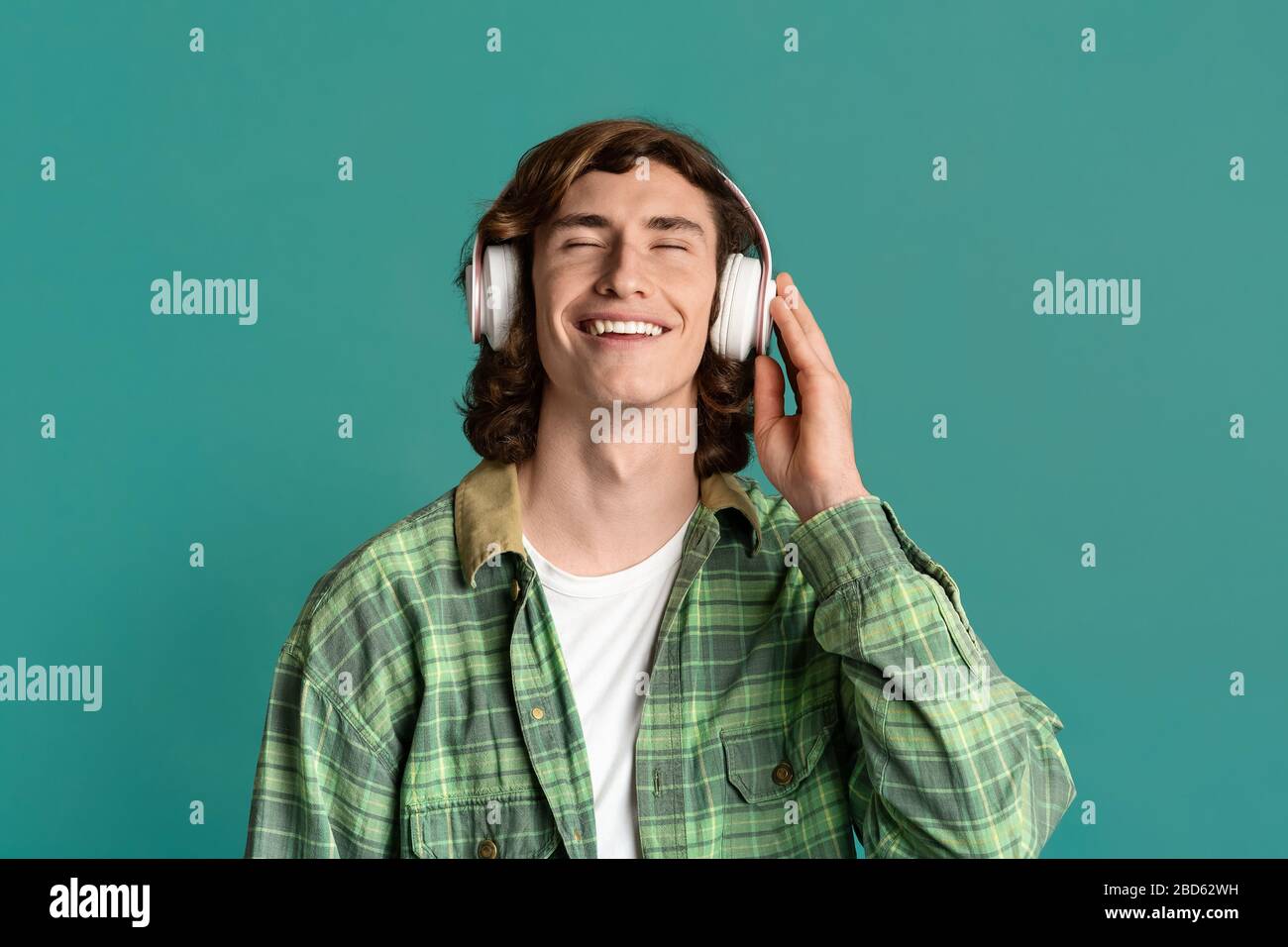 Funky guy with closed eyes enjoying his favorite music in headphones ...