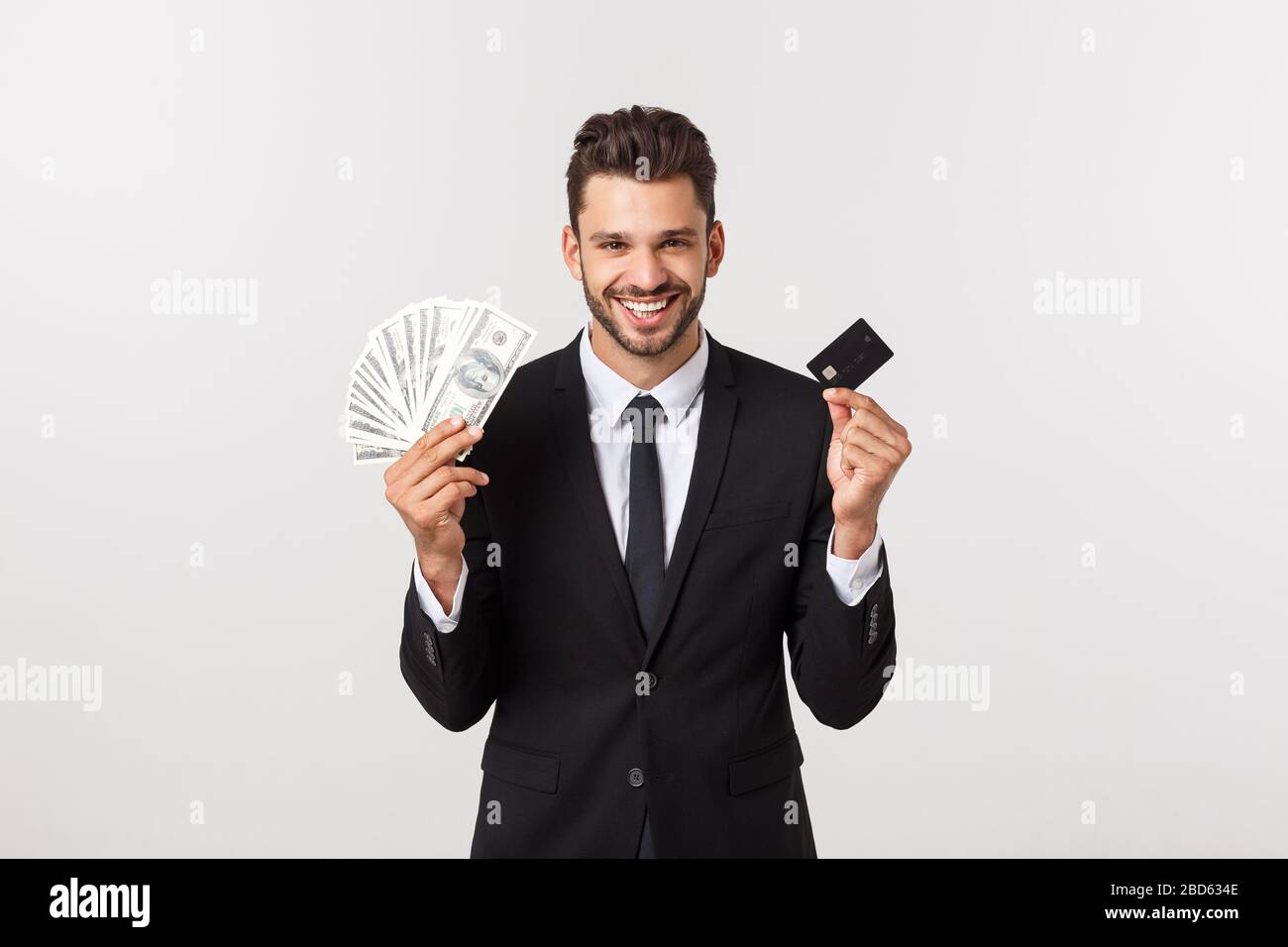 Young successful handsome rich business man in black suit holding ...