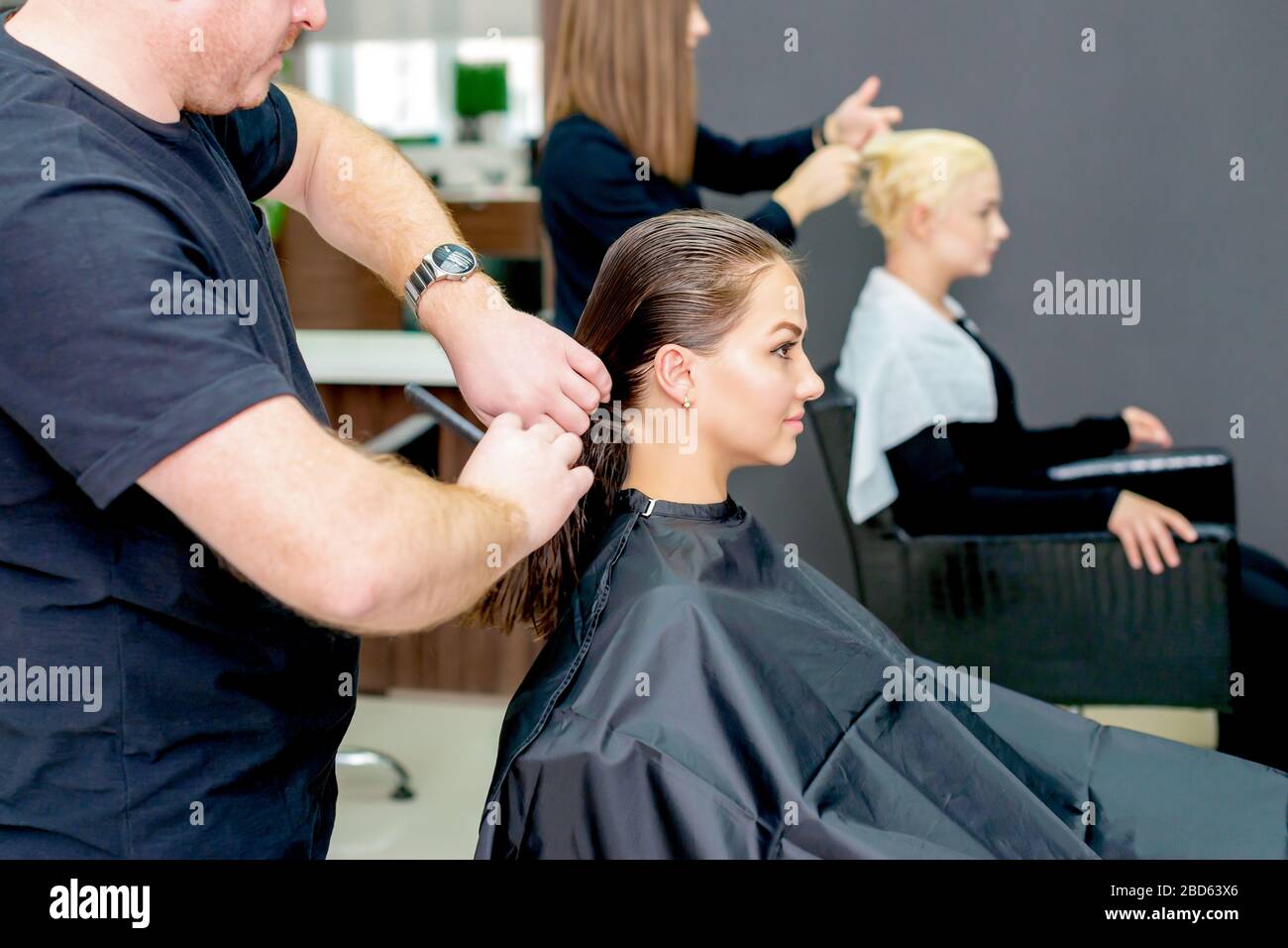 Woman receiving haircut closeup by hairdresser in hair salon Stock ...