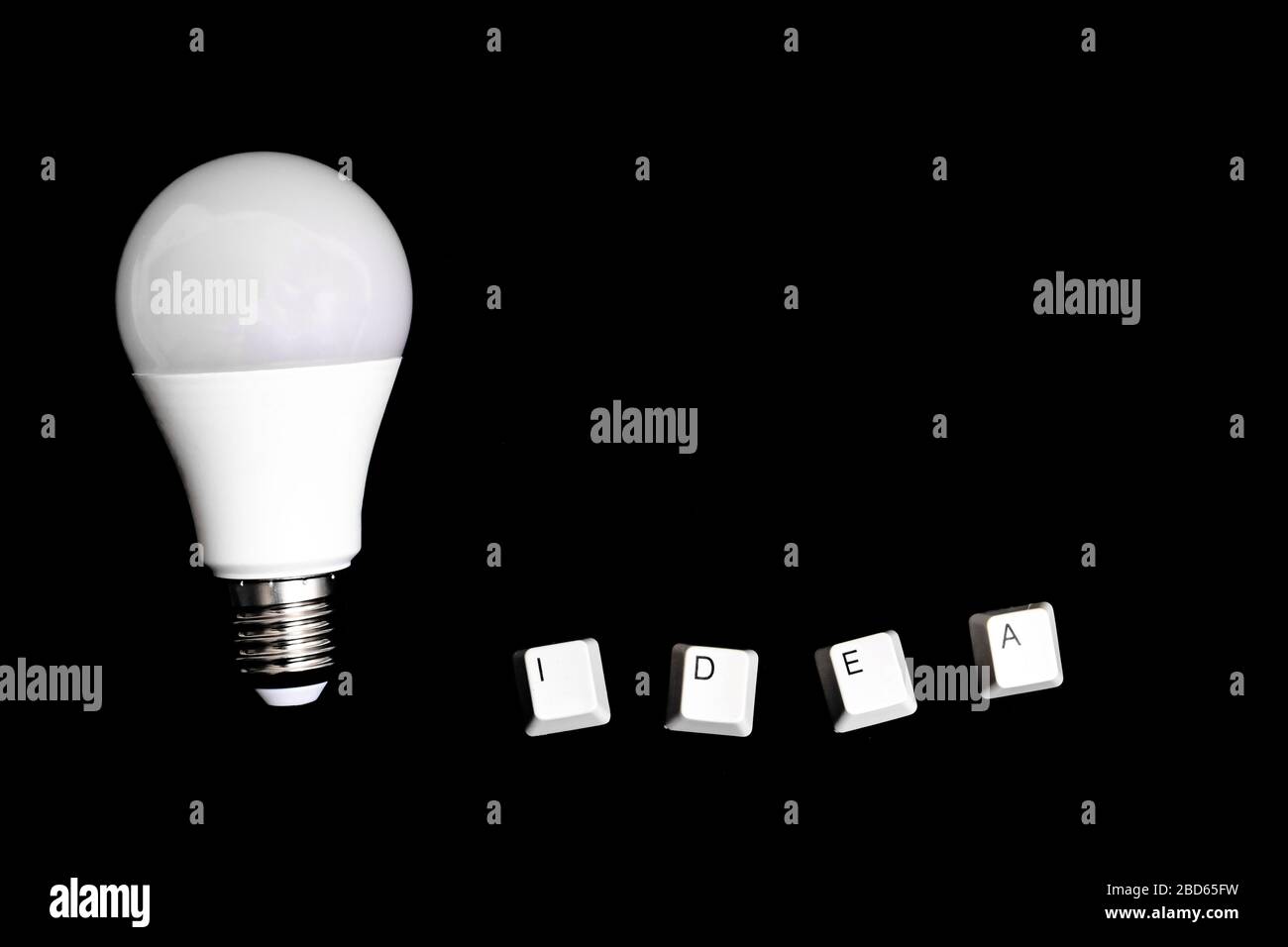 White light bulb and word idea on black background Stock Photo - Alamy
