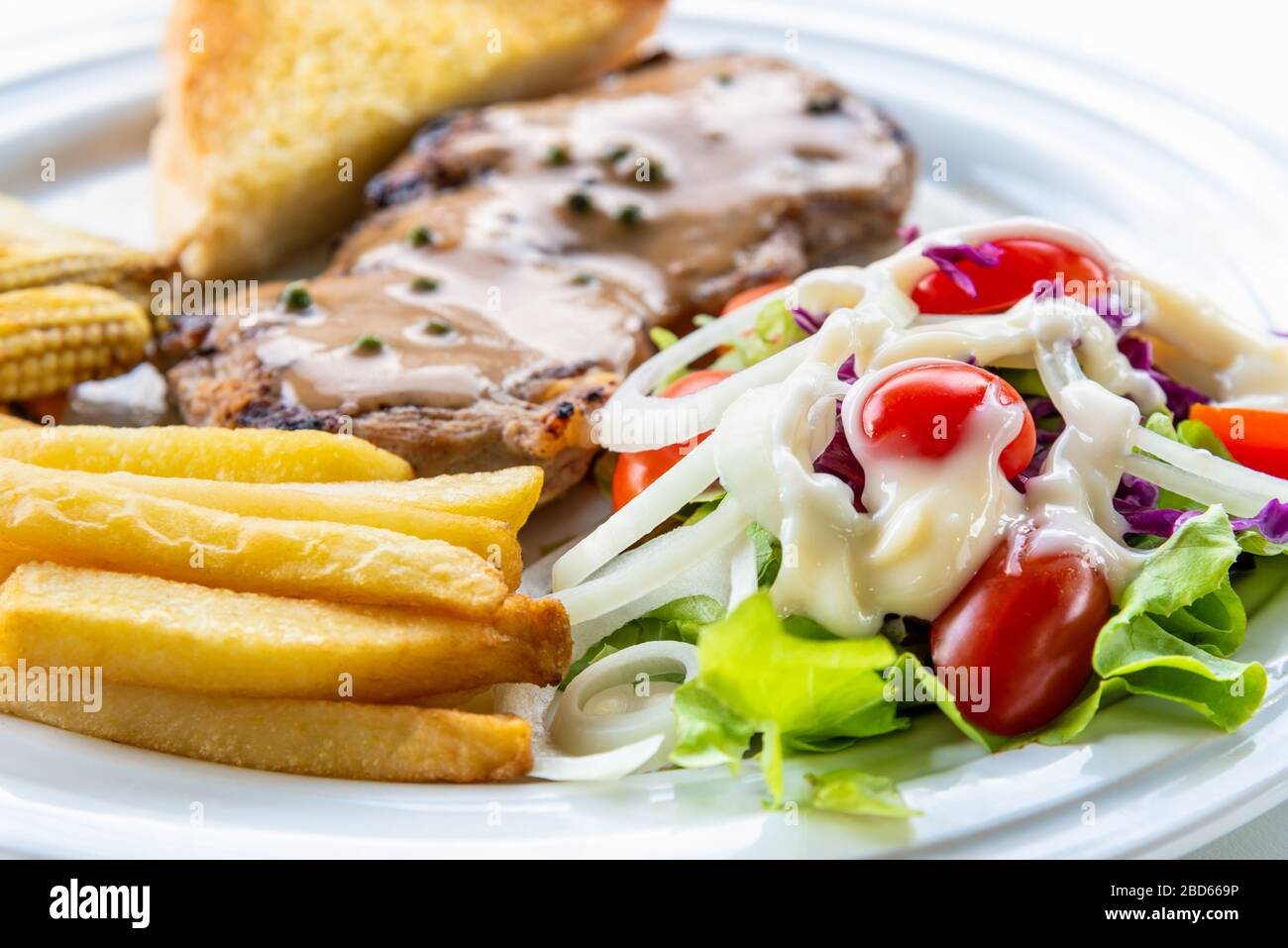 Closeup side view vegetable salad topped mayonnaise with tomato, onion ...