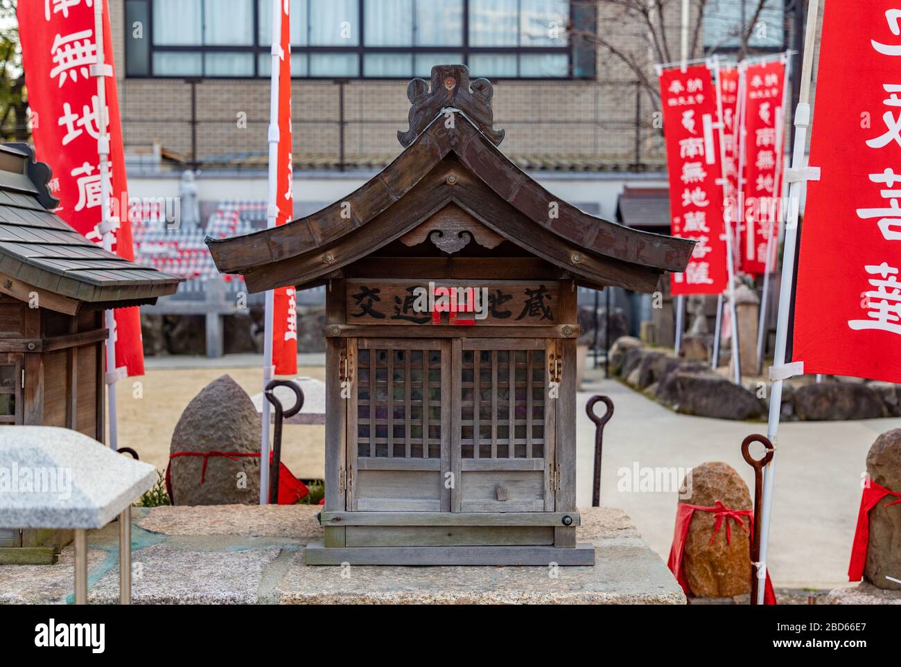 A picture of a small miniature temple on display on a cemetery next to ...