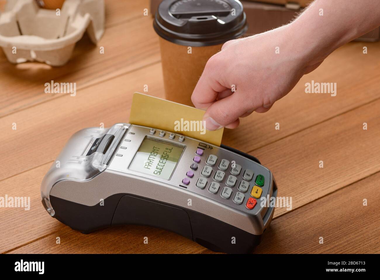 Man swipes a card into the terminal to pay for coffee Stock Photo - Alamy