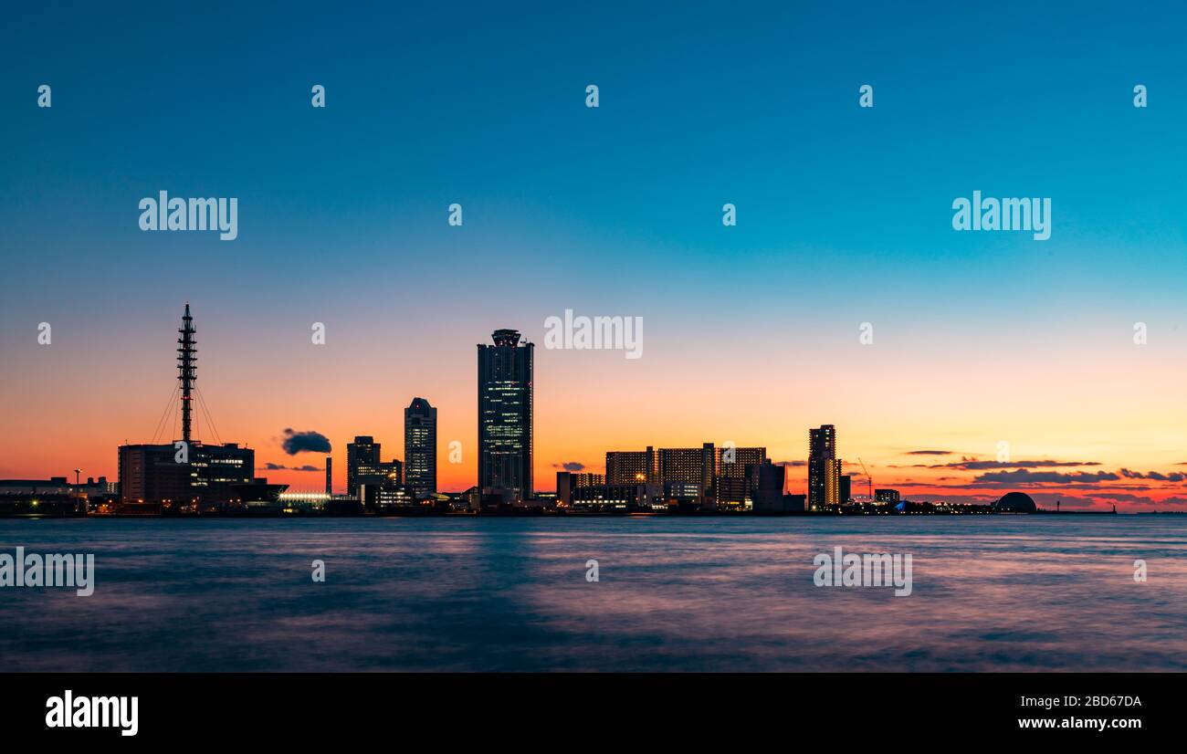 A picture of the sun setting over the Osaka bay and the Cosmosquare ...