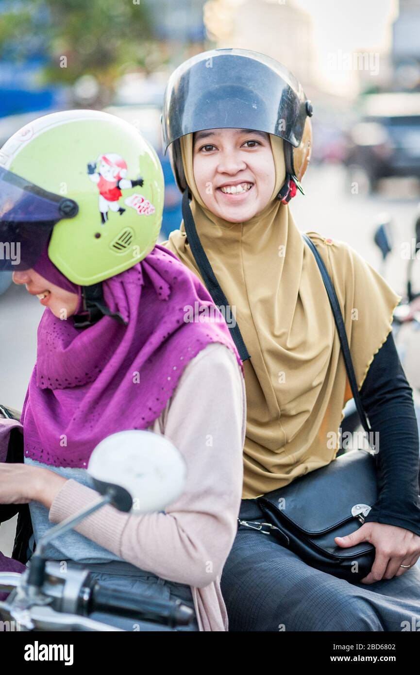 Two Young Cambodian Girls Navigate The Busy Traffic Of Phnom Penh