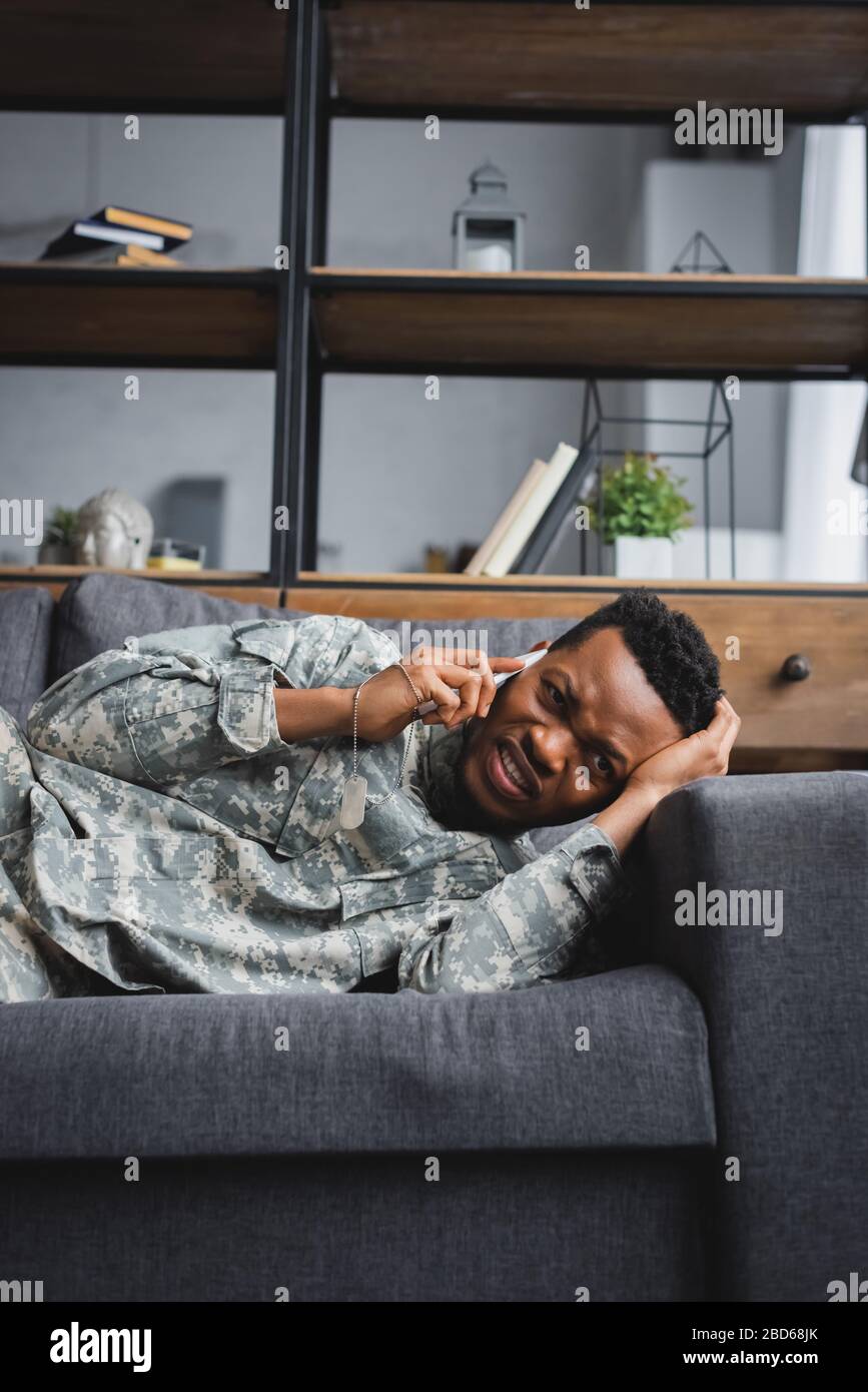 stressed african american soldier in military uniform crying while ...