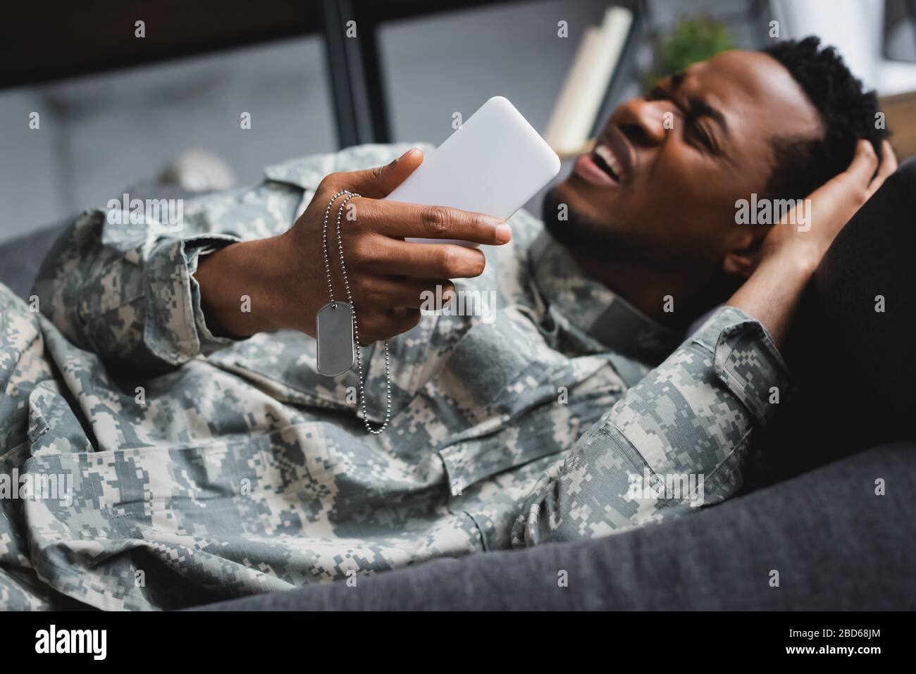 stressed african american soldier crying while holding army badge and ...