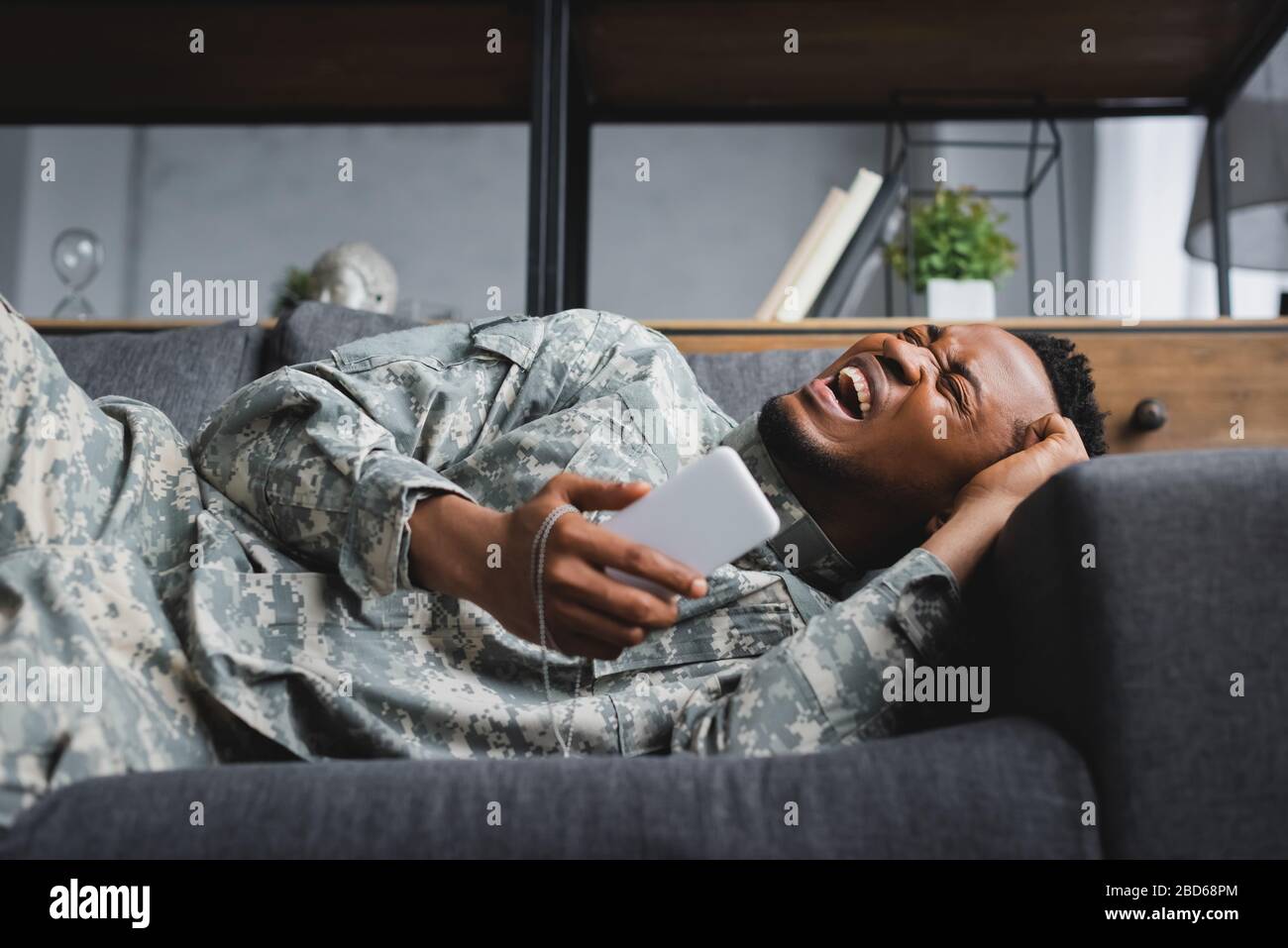 stressed african american soldier crying while holding army badge and ...