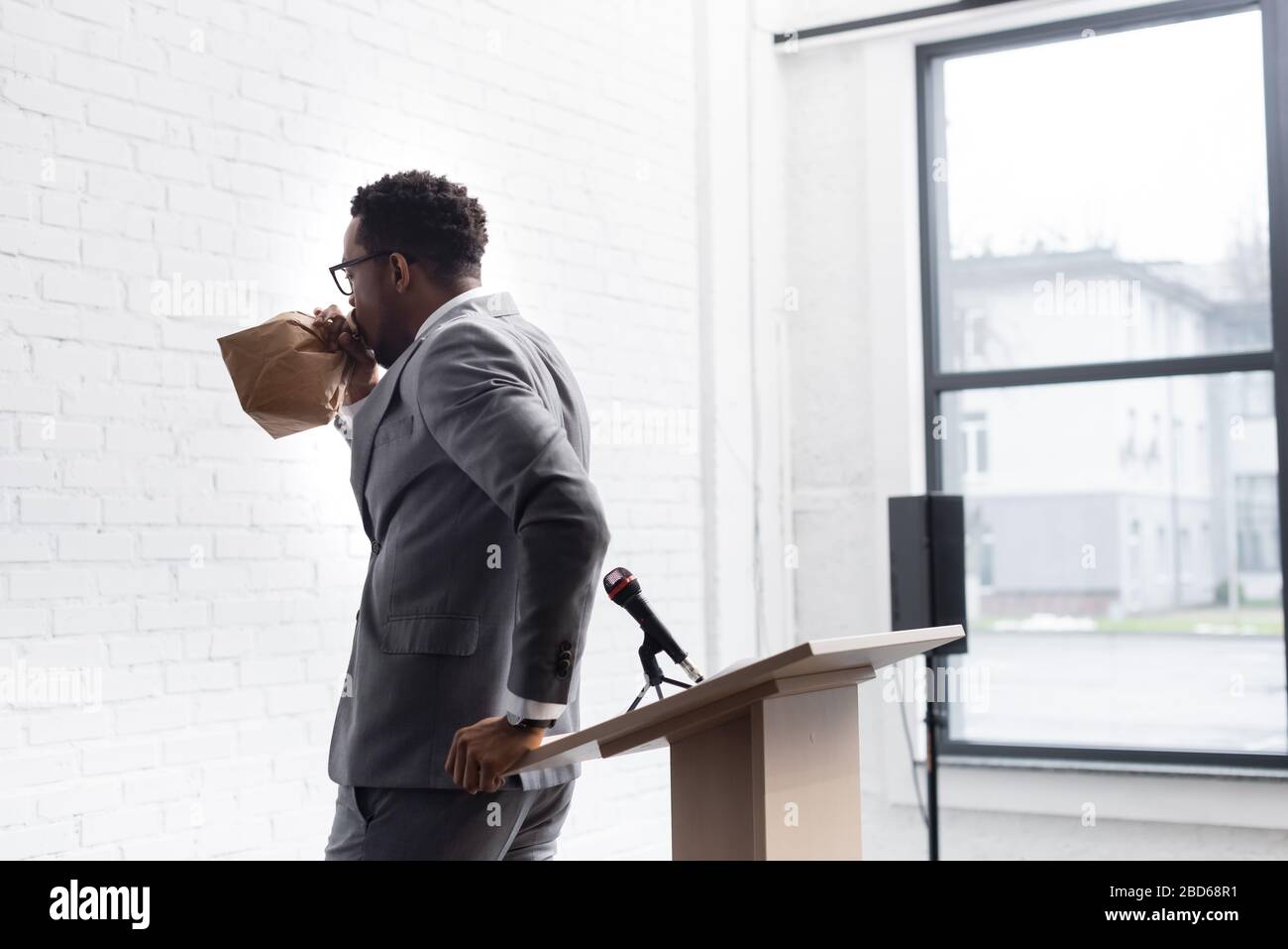 nervous african american speaker breathing with paper bag and having ...