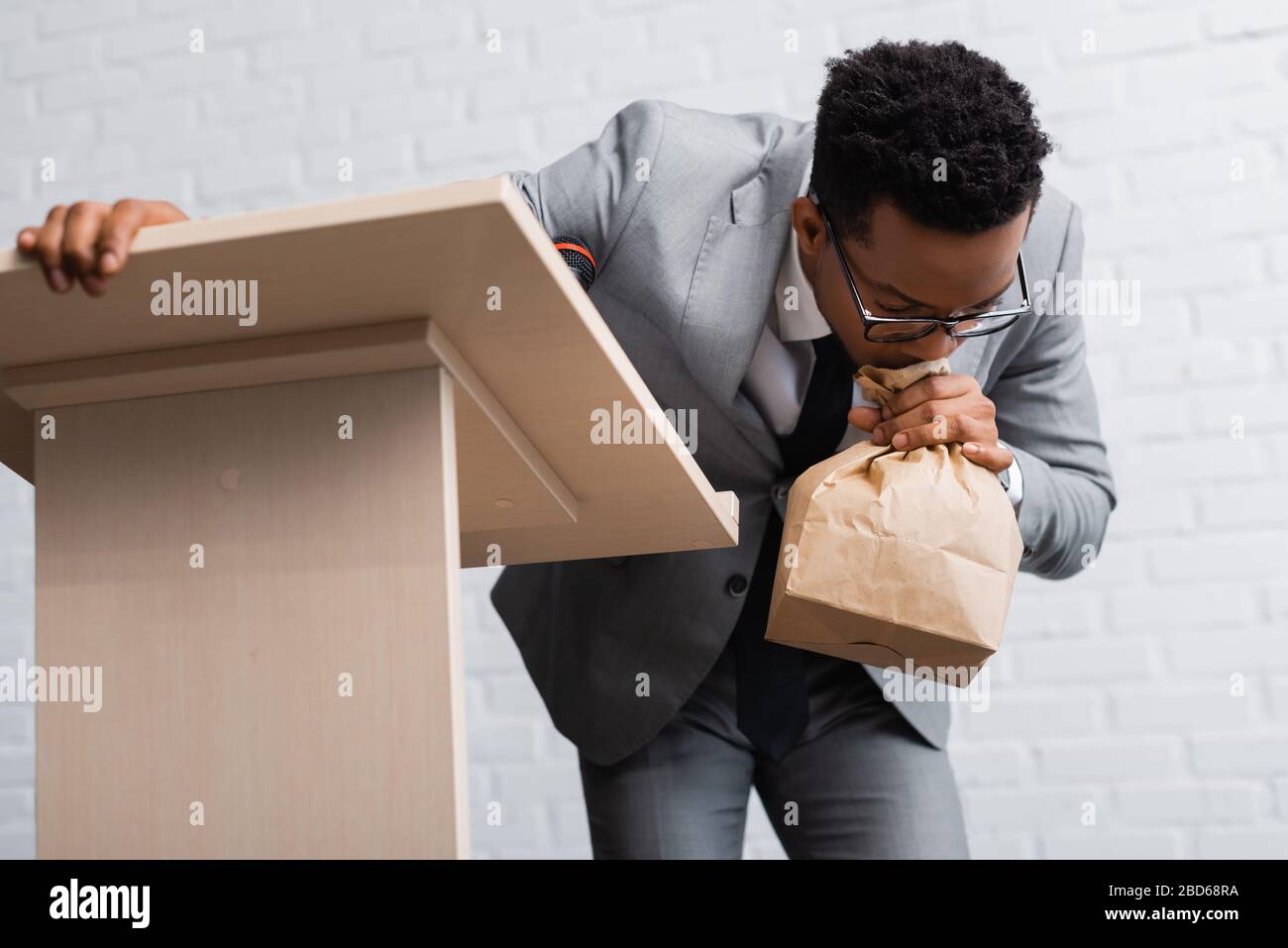 nervous african american businessman breathing with paper bag and ...