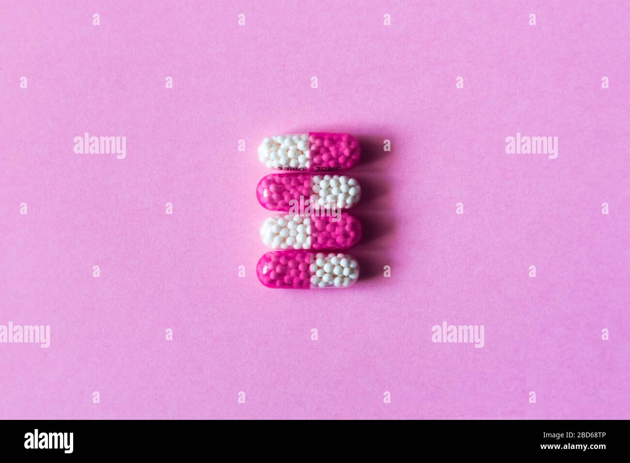 Heap of colorfull pills, tablets, capsules on pink background. Drug ...