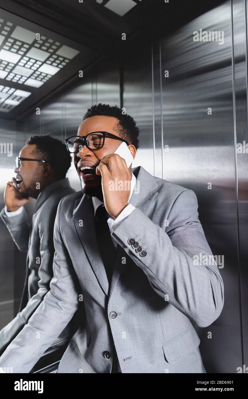 stressed african american businessman crying and talking on smartphone ...