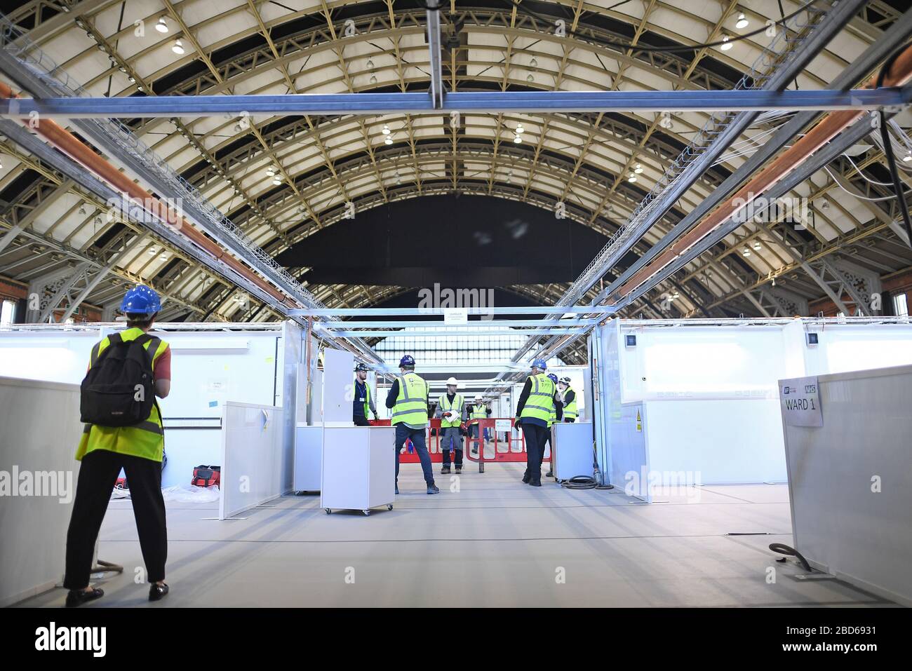 Construction workers at the new temporary NHS Nightingale Hospital ...