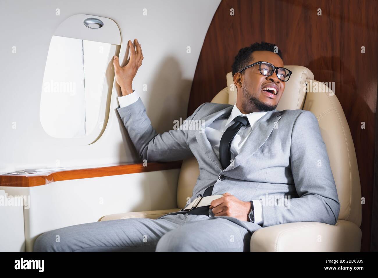 african american businessman holding safety belt and suffering from ...