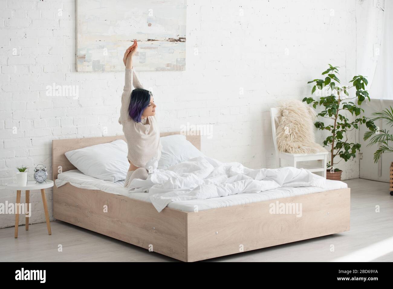 Girl stretching on bed alarm clock hi-res stock photography and images ...