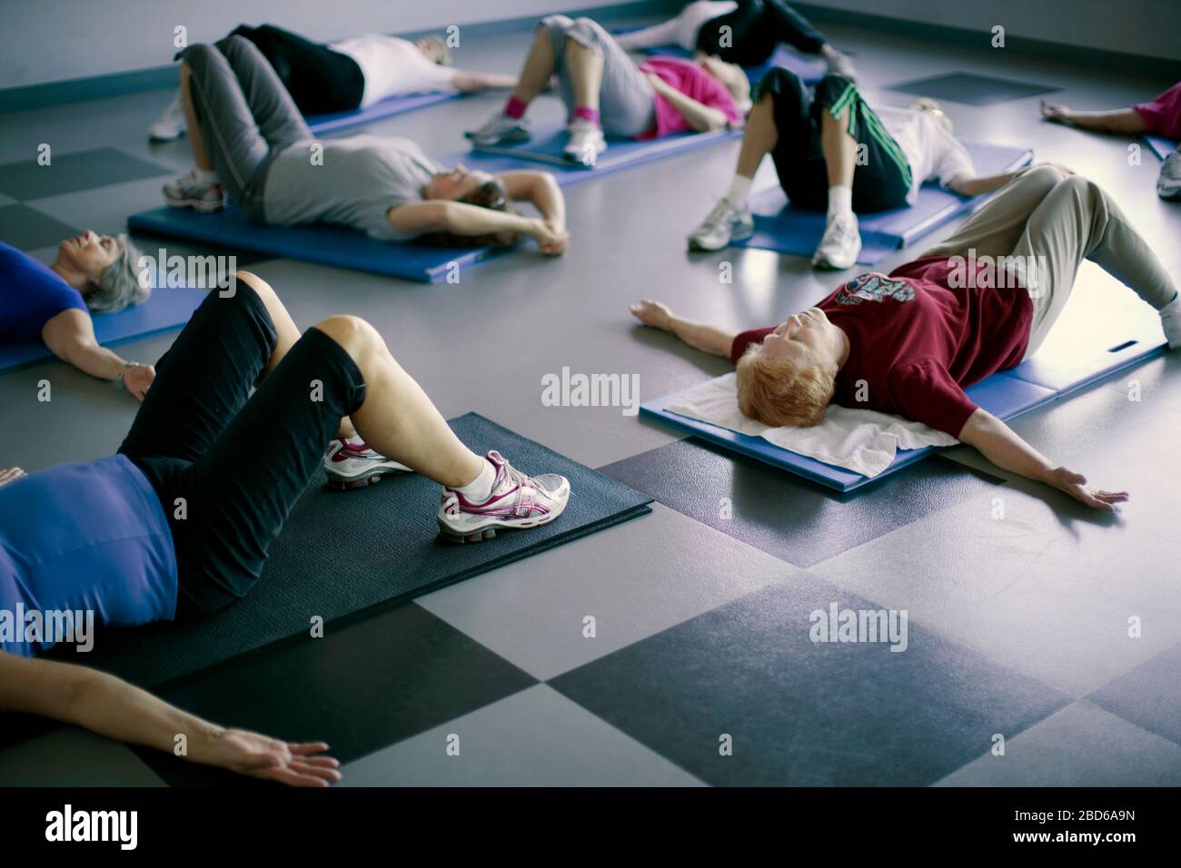 Elderly exercise class stretches on mat Stock Photo - Alamy