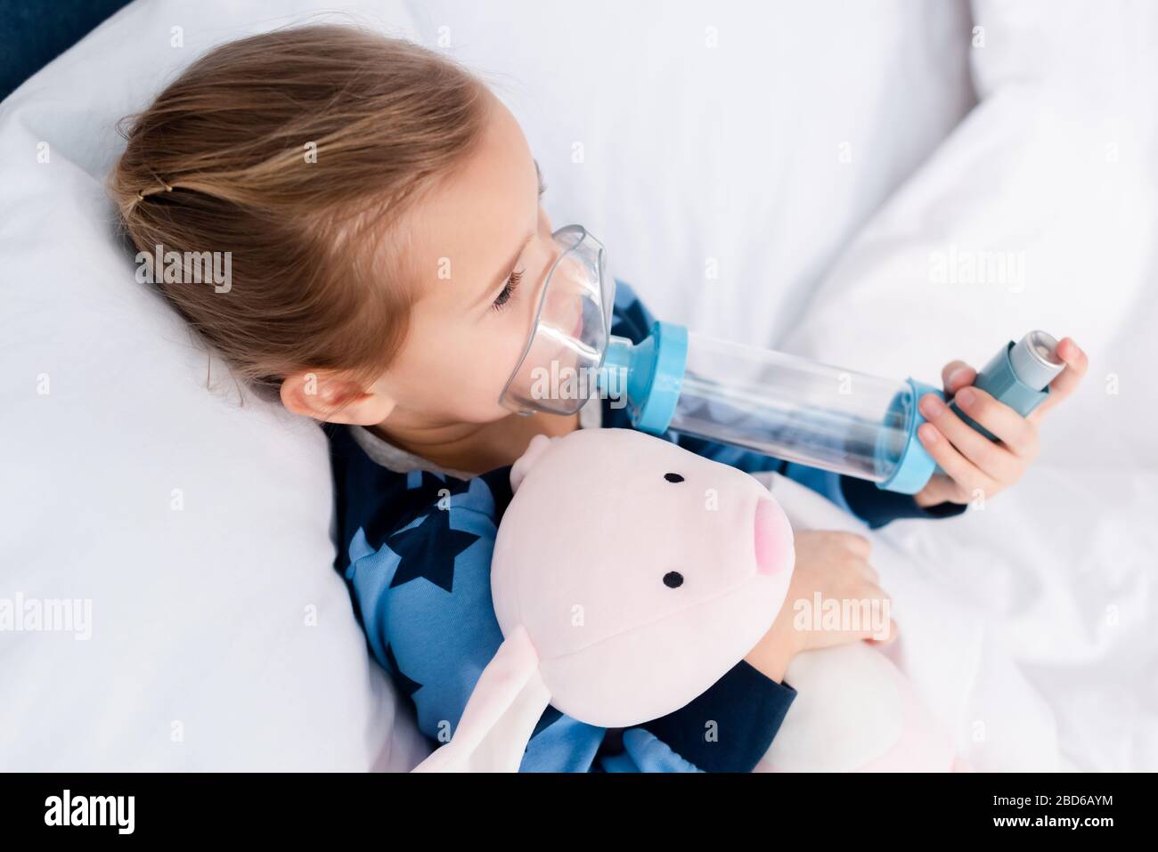 sick kid using inhaler with spacer and holding soft toy Stock Photo - Alamy