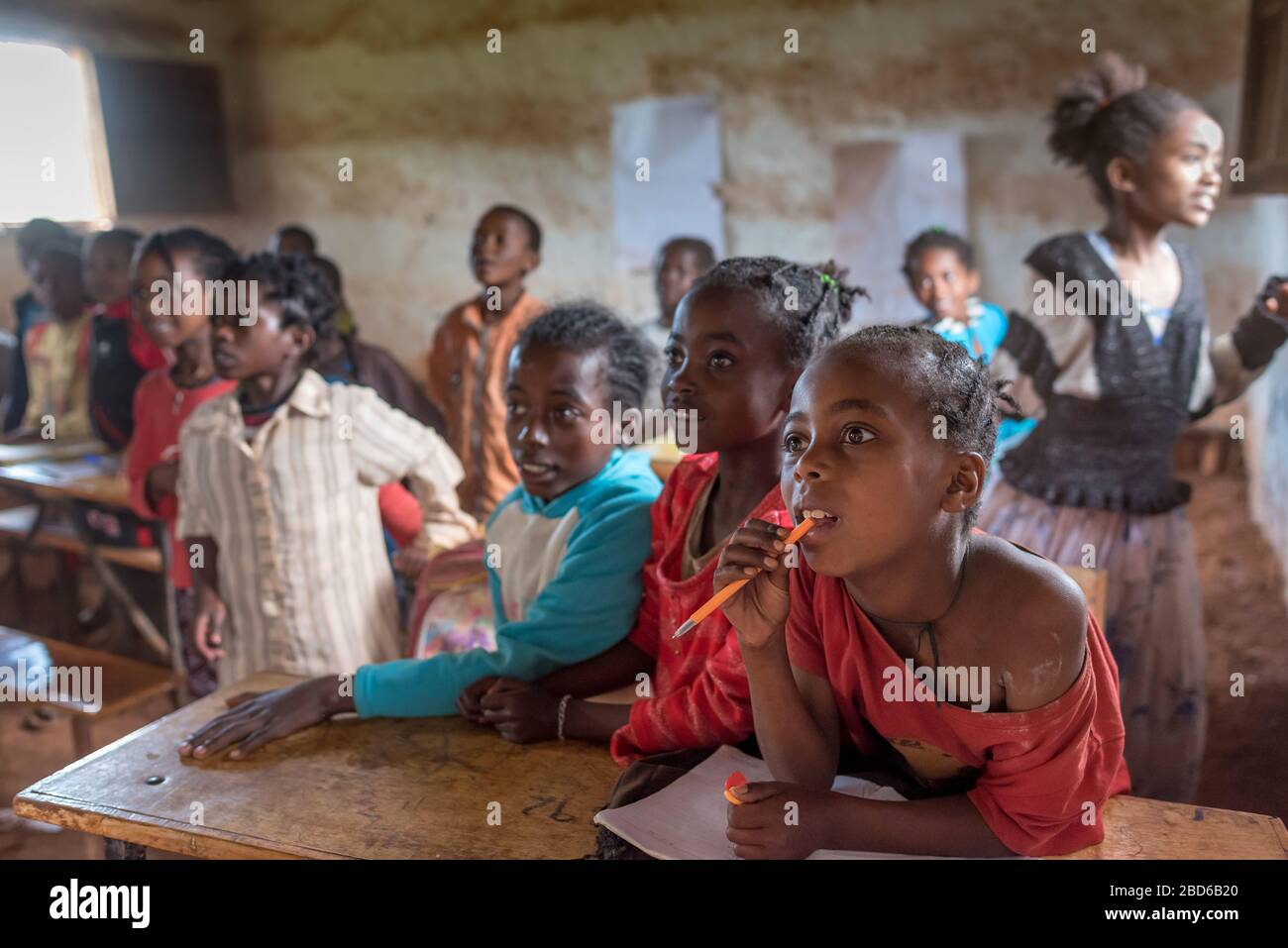 School children in mud walled classroom answer questions, members of ...