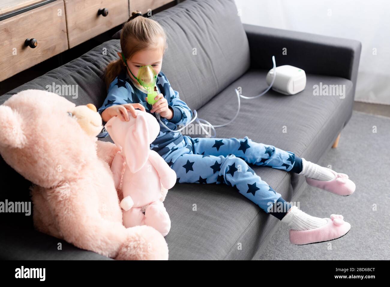asthmatic kid using compressor inhaler near soft toys Stock Photo - Alamy