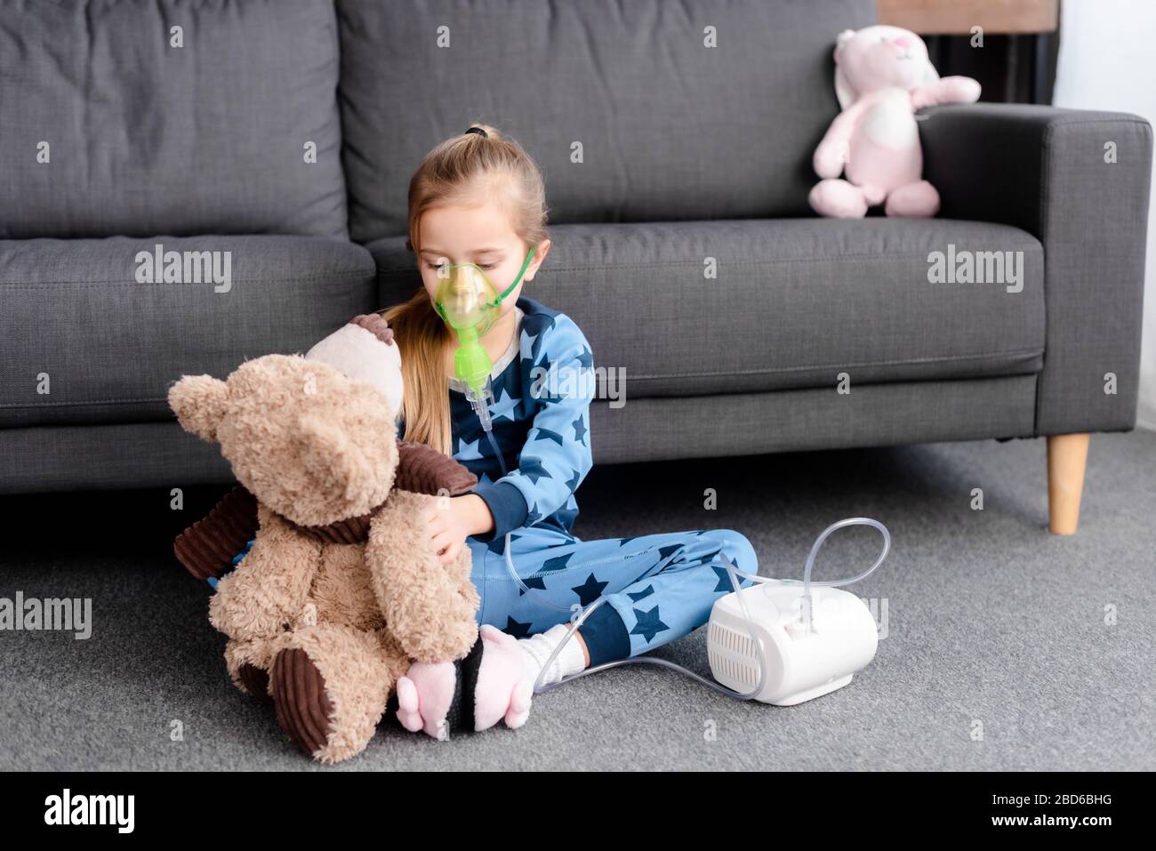 asthmatic child using compressor inhaler and holding teddy bear Stock ...