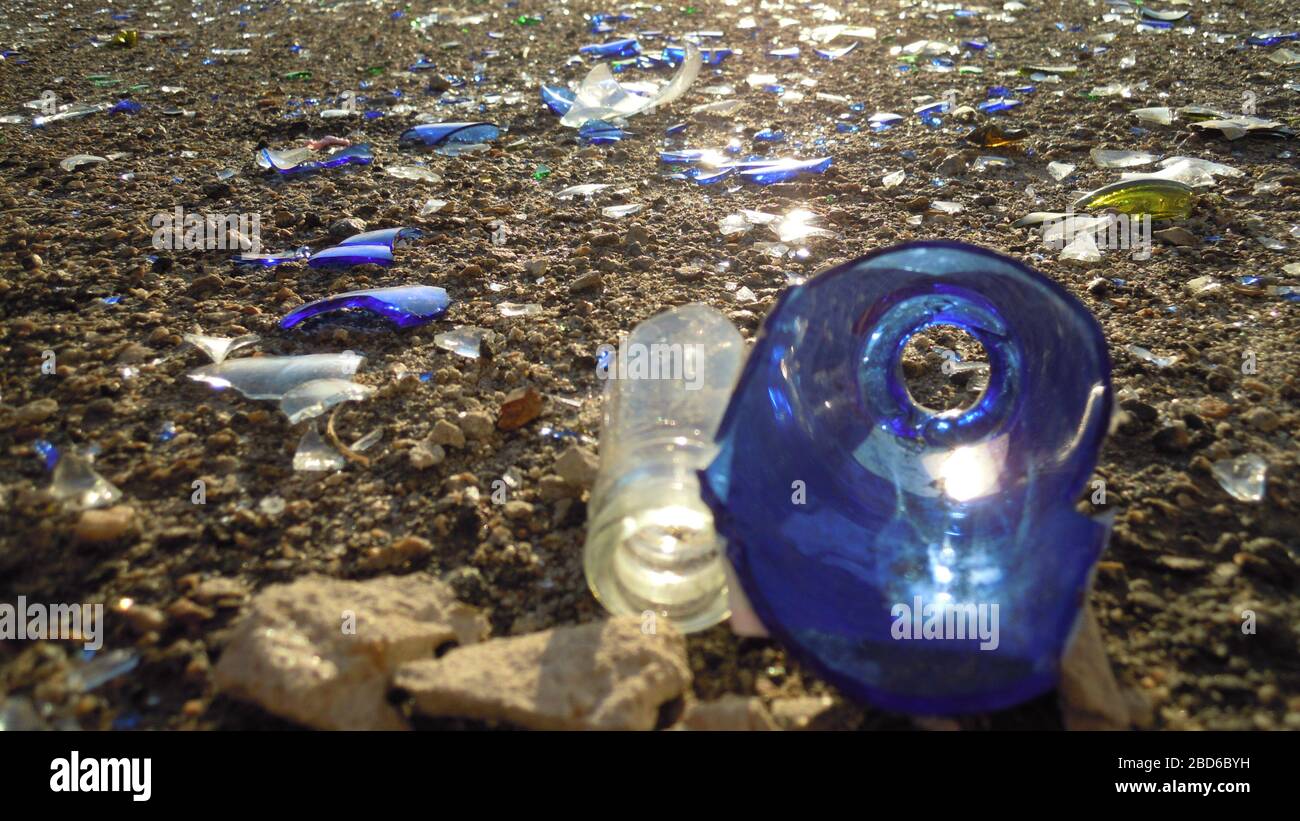 Broken glass bottles of beer and alcohol on the sidewalk. Urban ...