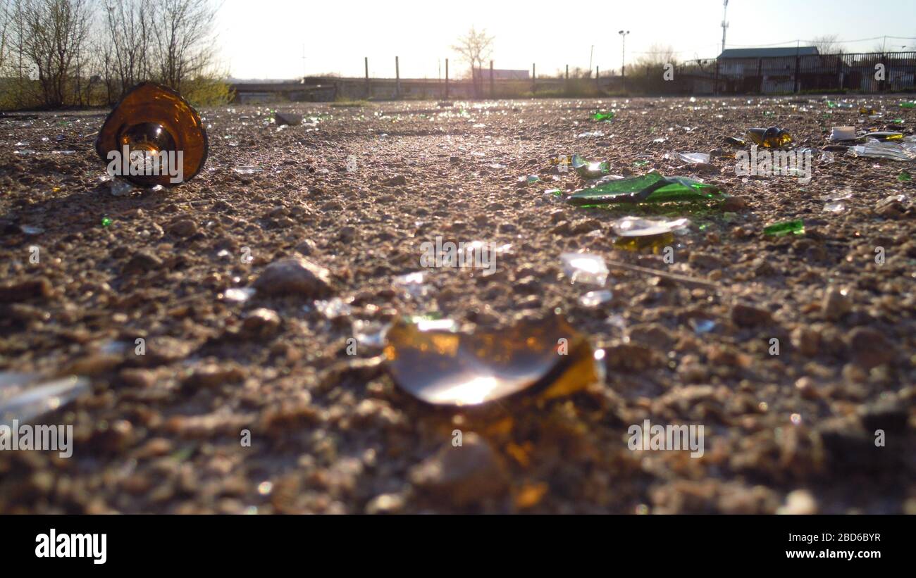 Broken glass bottles of beer and alcohol on the sidewalk. Urban ...