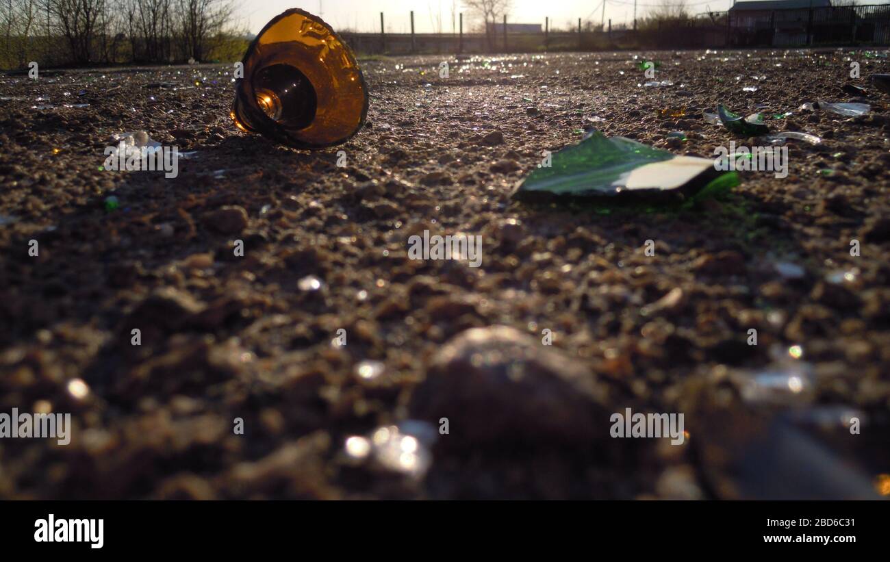 Broken glass bottles of beer and alcohol on the sidewalk. Urban ...