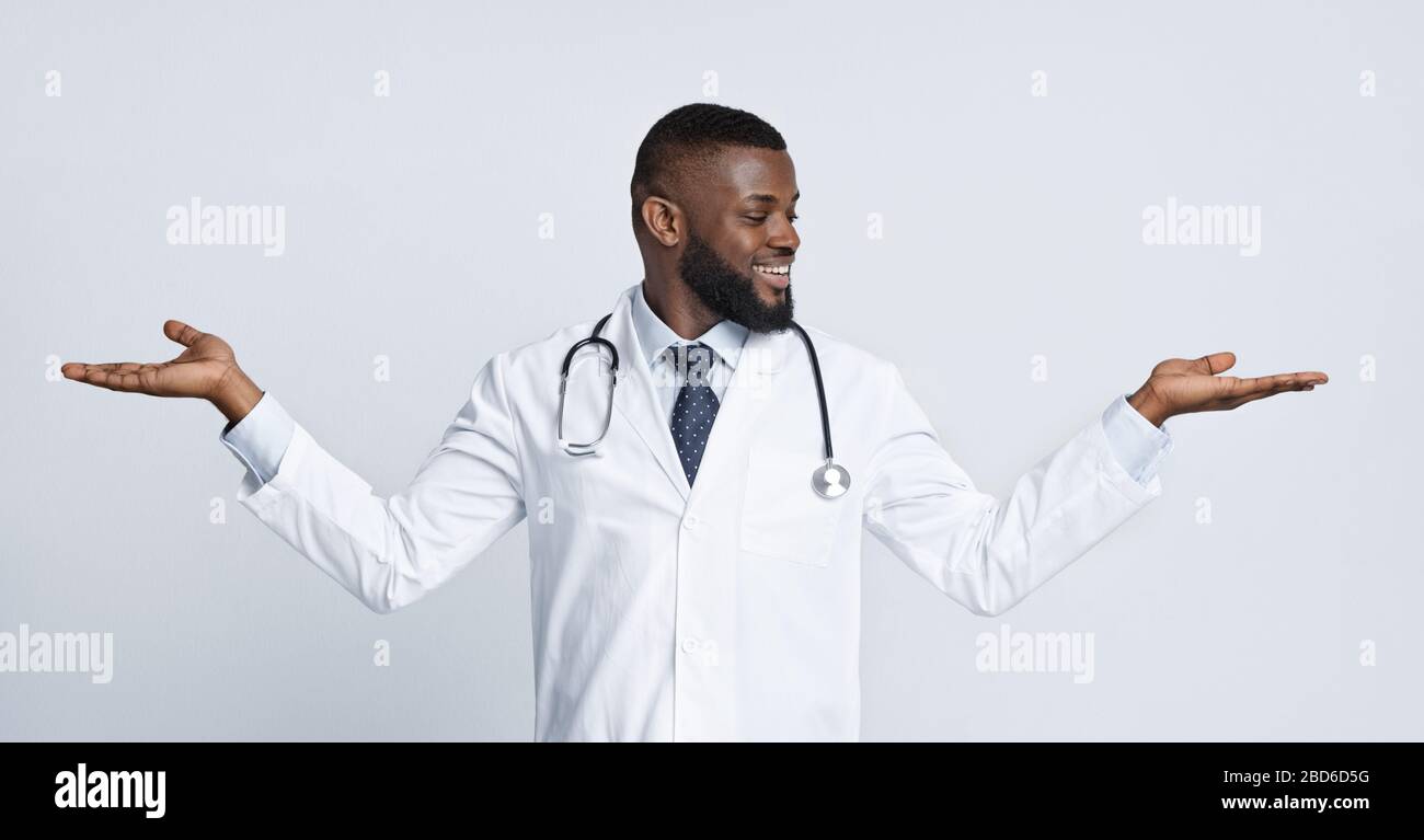 Smiling african doctor holding something invisible on his hands Stock ...
