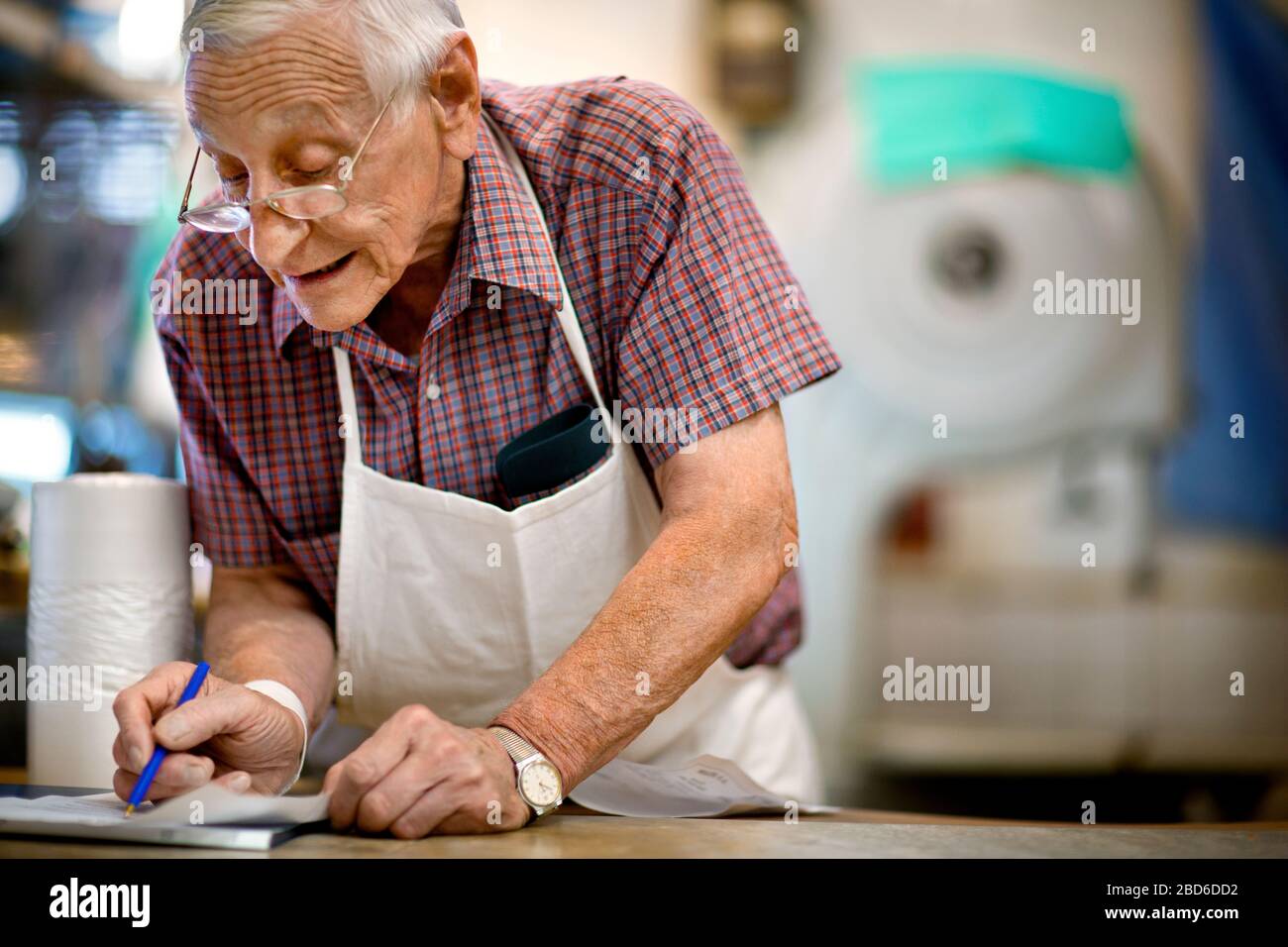 Portrait of cheerful elderly butcher at work Stock Photo - Alamy