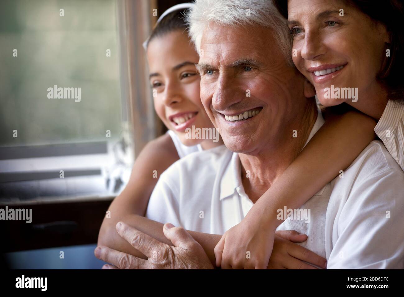 Happy family hugging in a cafe Stock Photo - Alamy