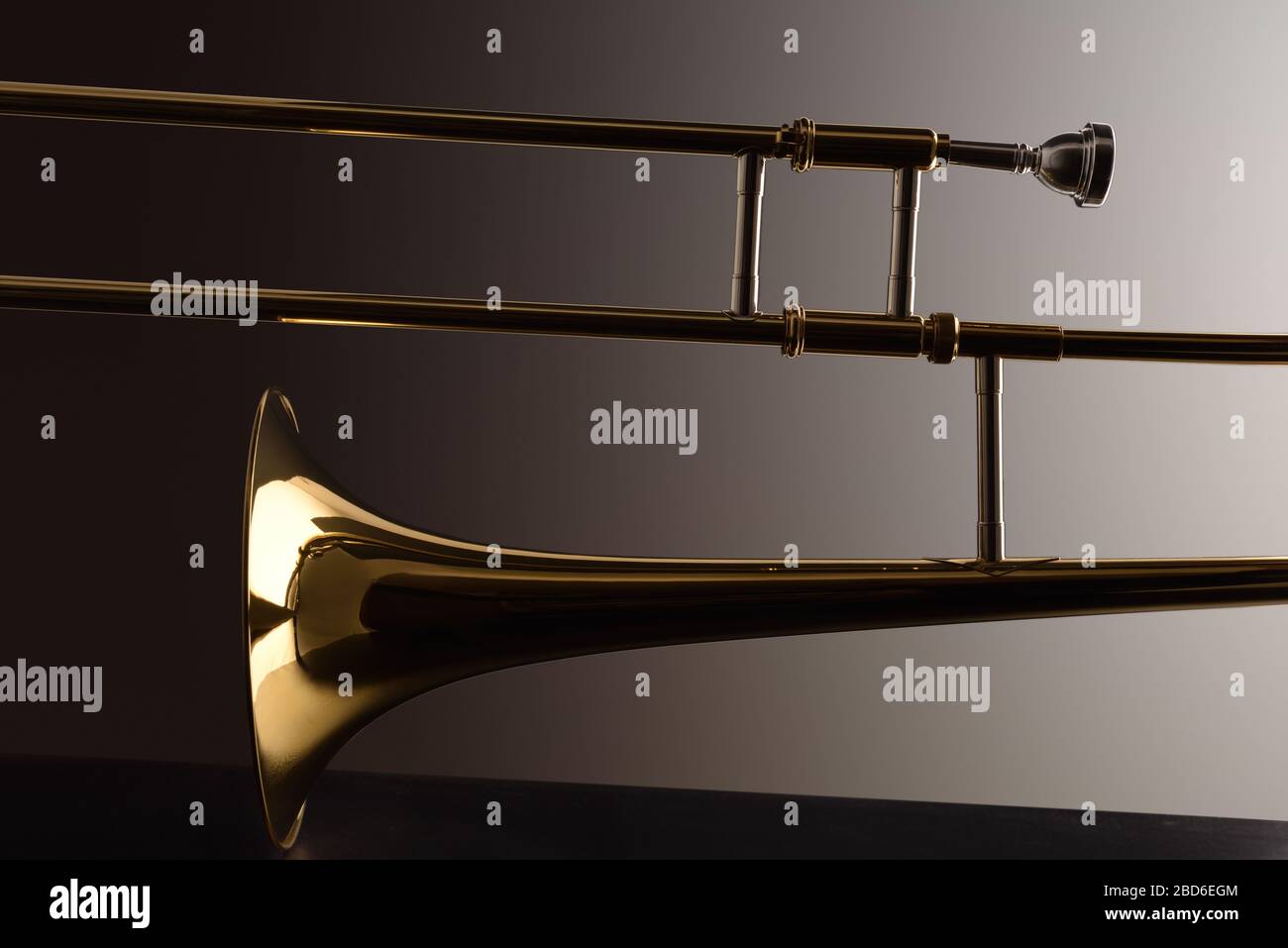 Backlit trombone on black base with gradient dark background. Side view ...