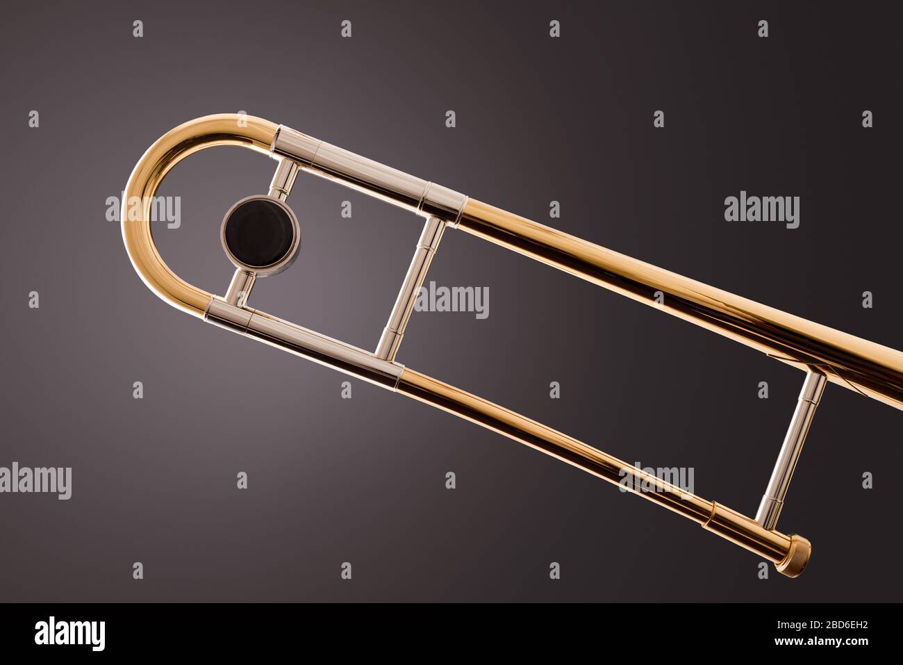 Tuning slide part of a trombone with gray gradient background. Side ...
