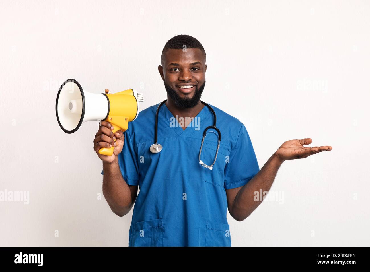 Black doctor in blue uniform using holding loudspeaker Stock Photo - Alamy