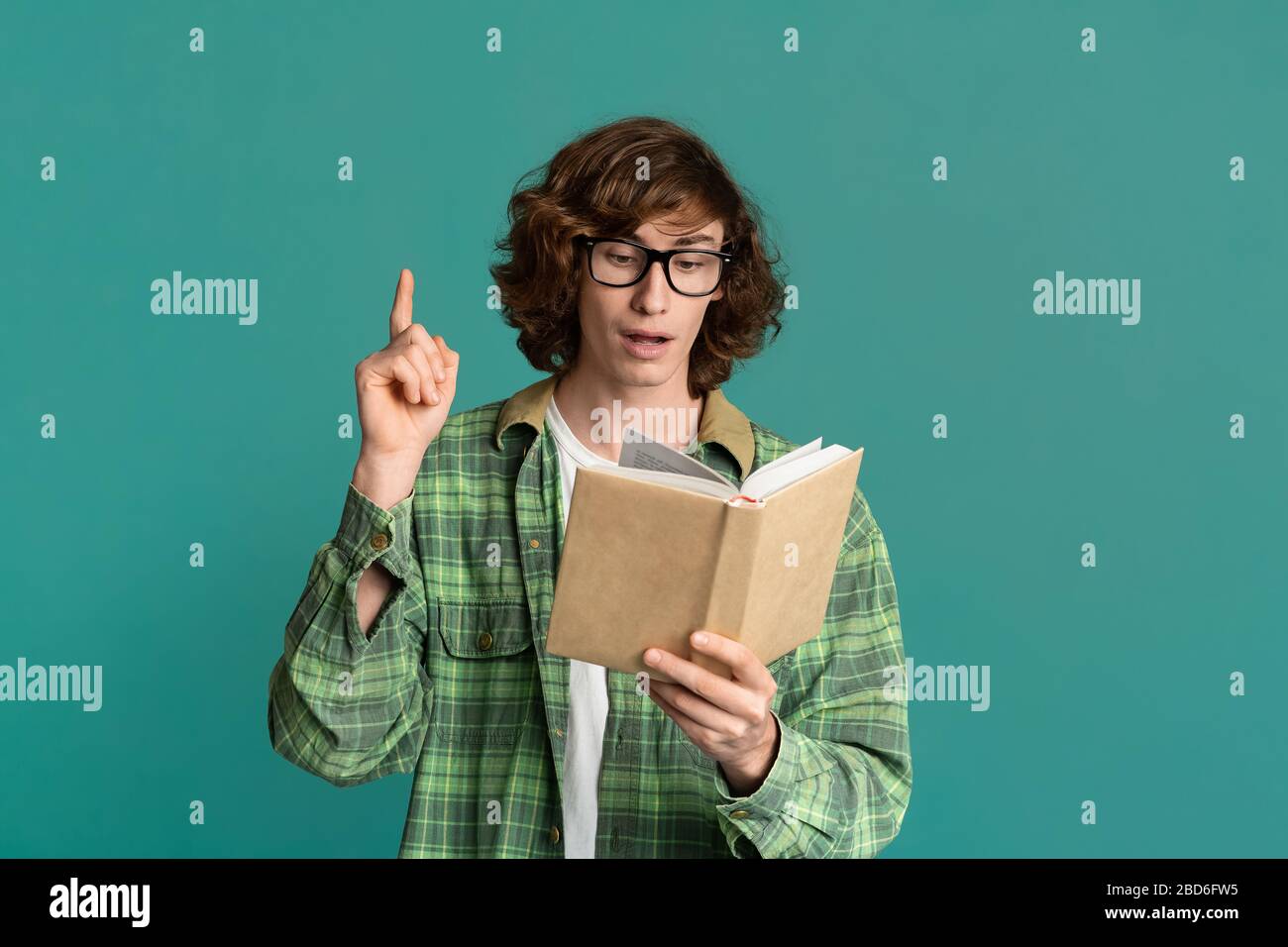 Hipster guy in glasses reading book and pointing finger up, having ...