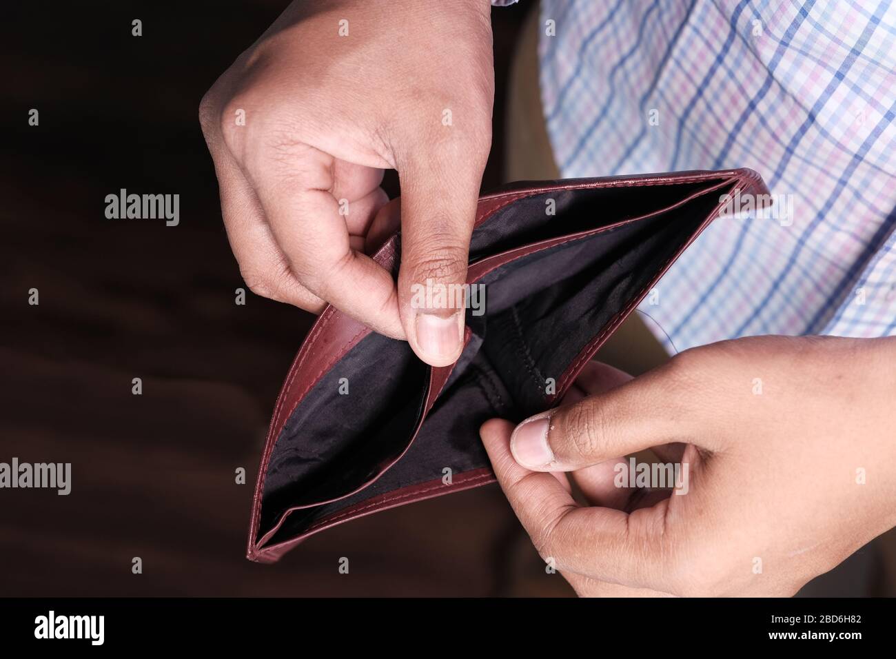 Empty wallet in the hands of an young man Stock Photo - Alamy