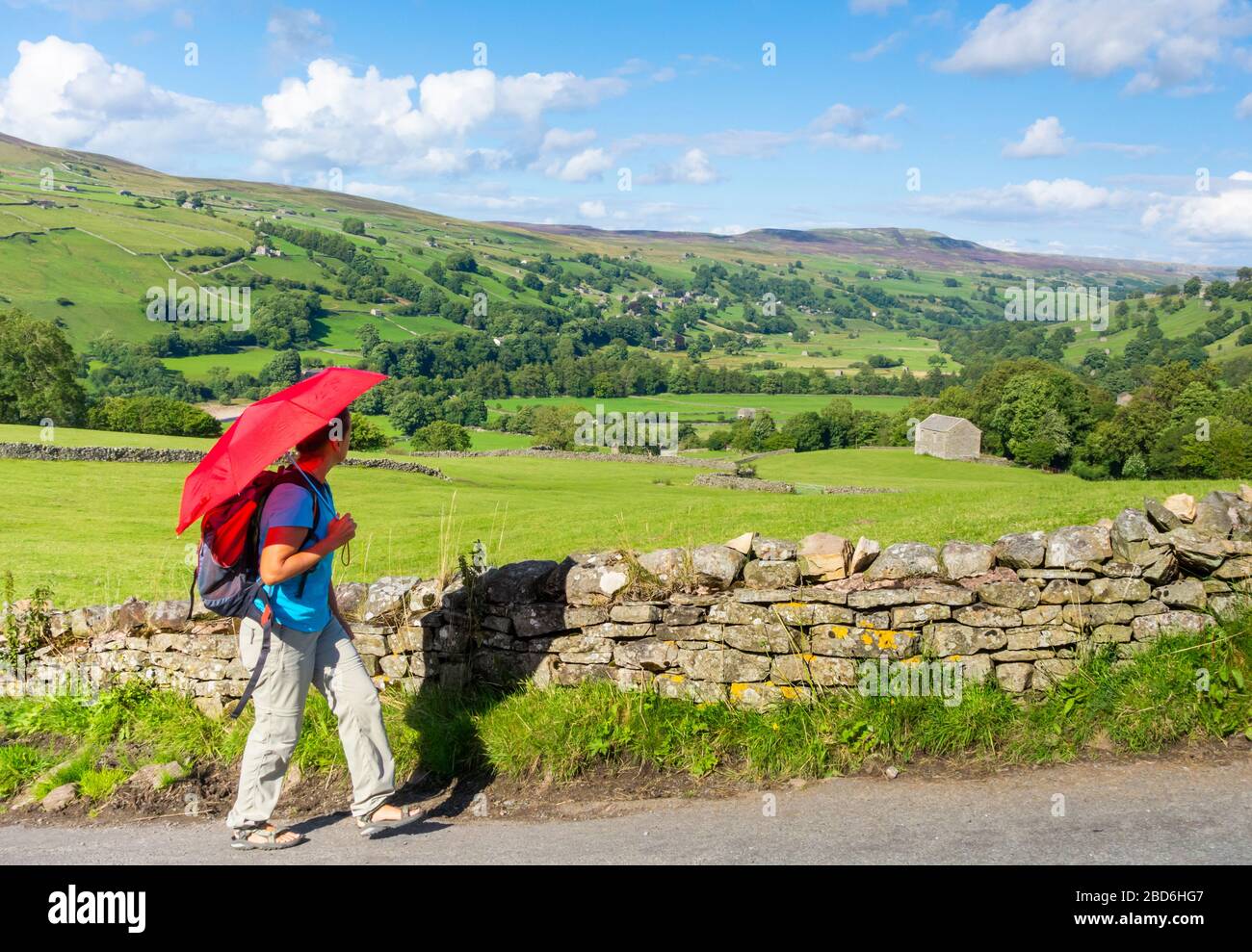 Female hiker, walker with red umbrella for sun protection near Crackpot ...