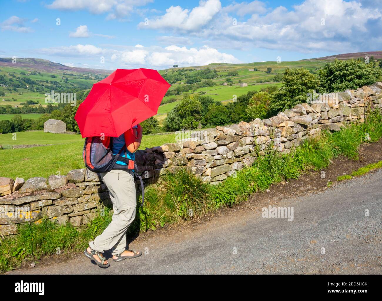 Female hiker, walker with red umbrella for sun protection near Crackpot ...